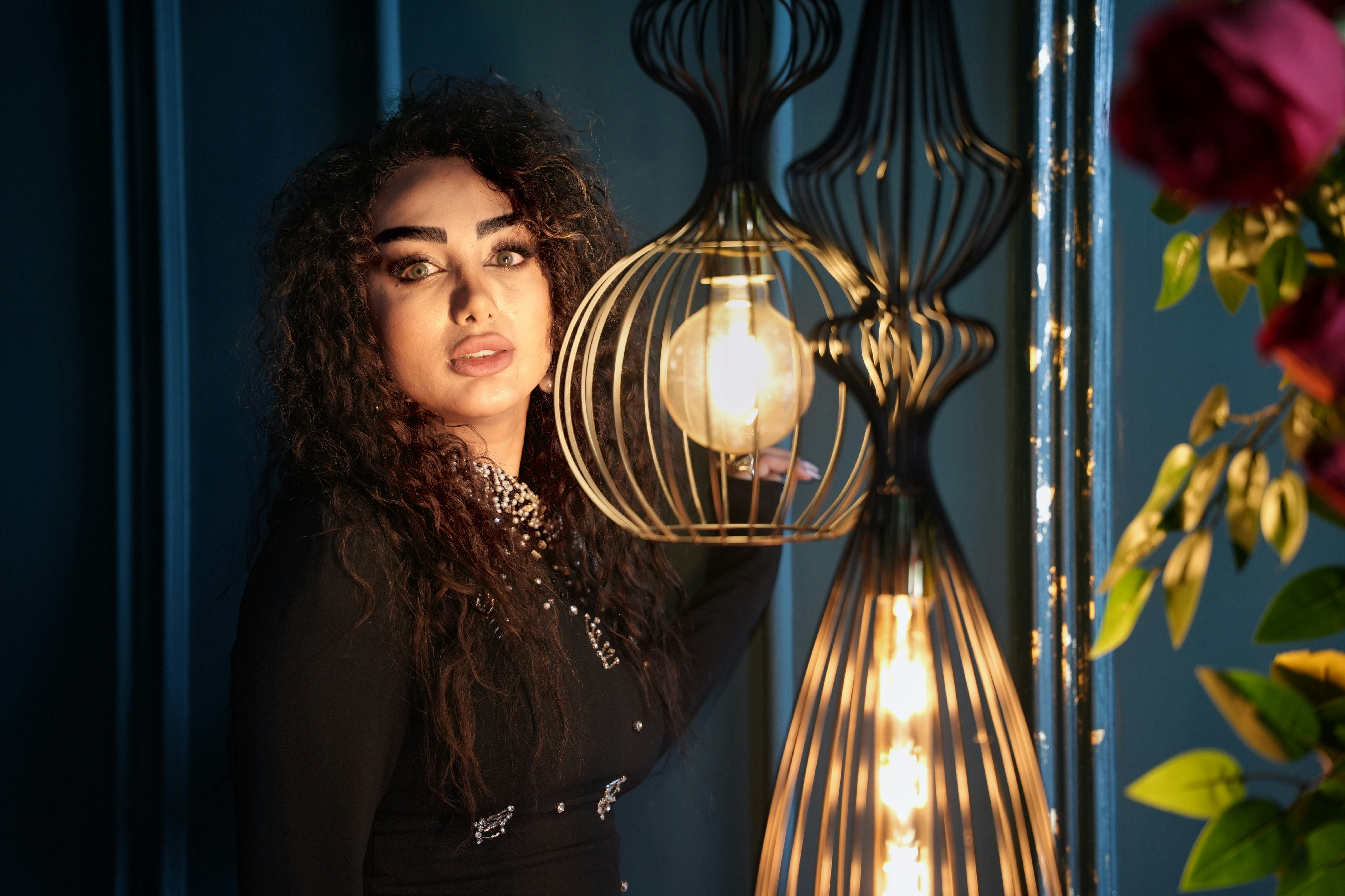 Woman posing with decorative lamps and flowers