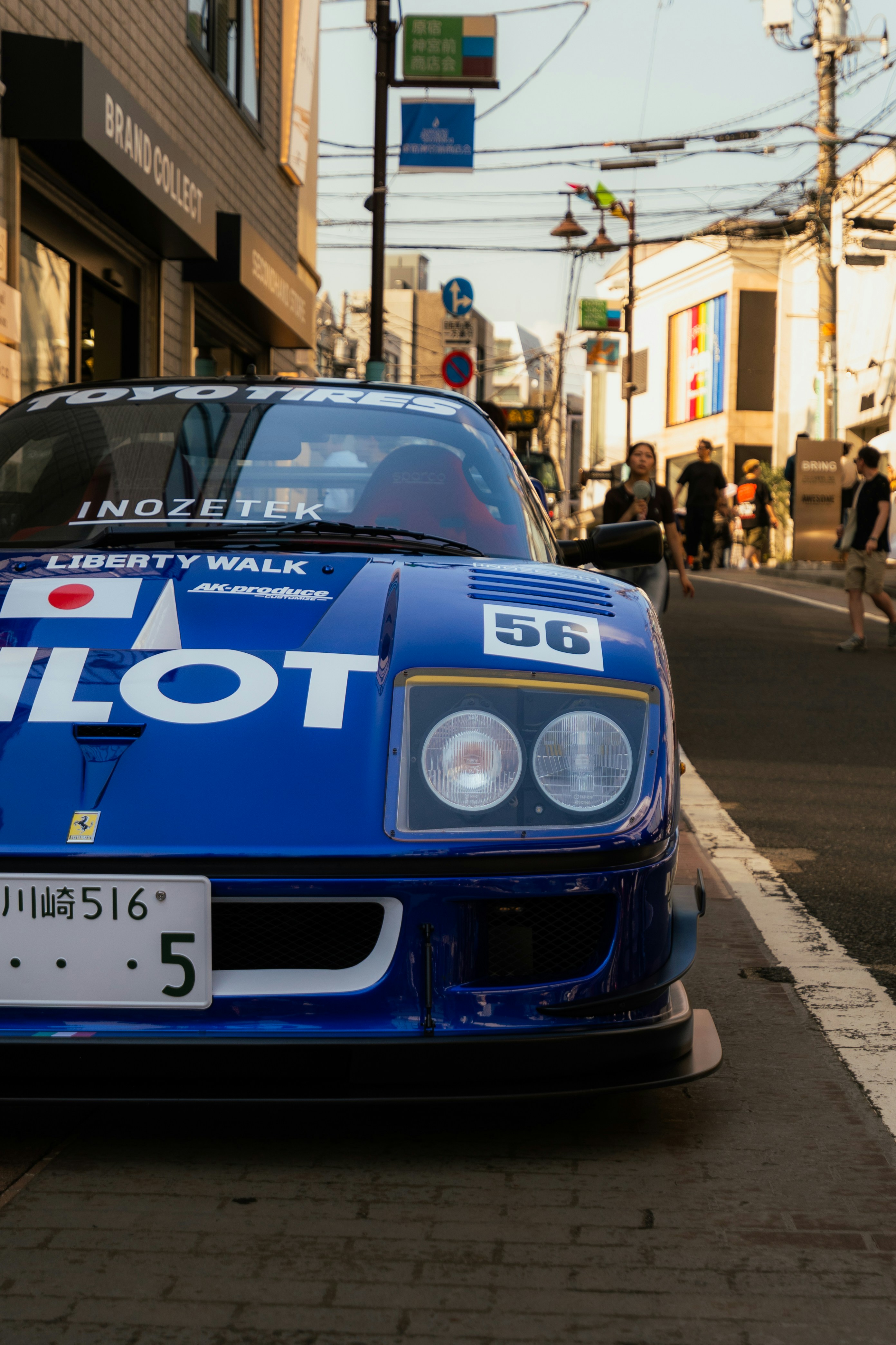 Blue Rally Car Anchors a Lively Urban Street Scene