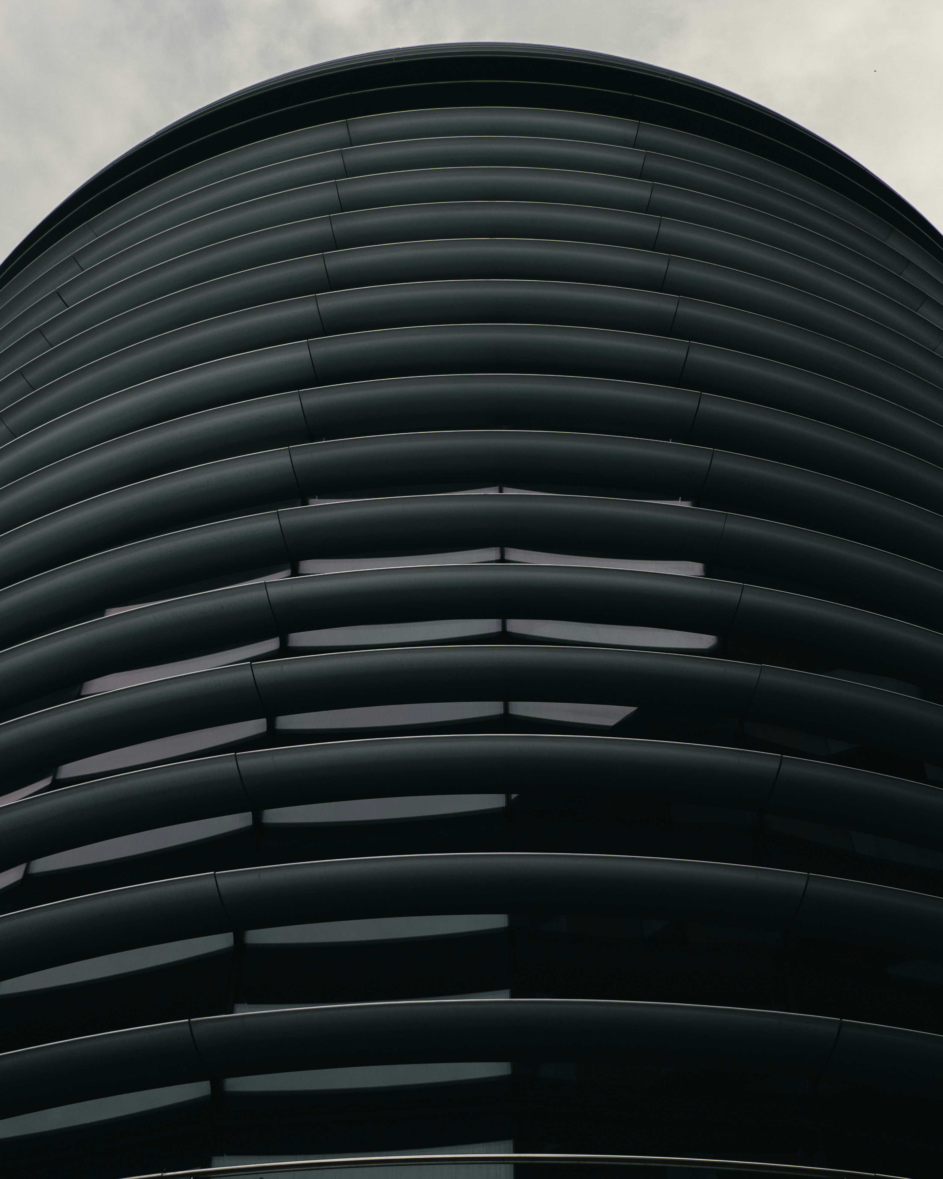 Curved dark building facade with horizontal lines
