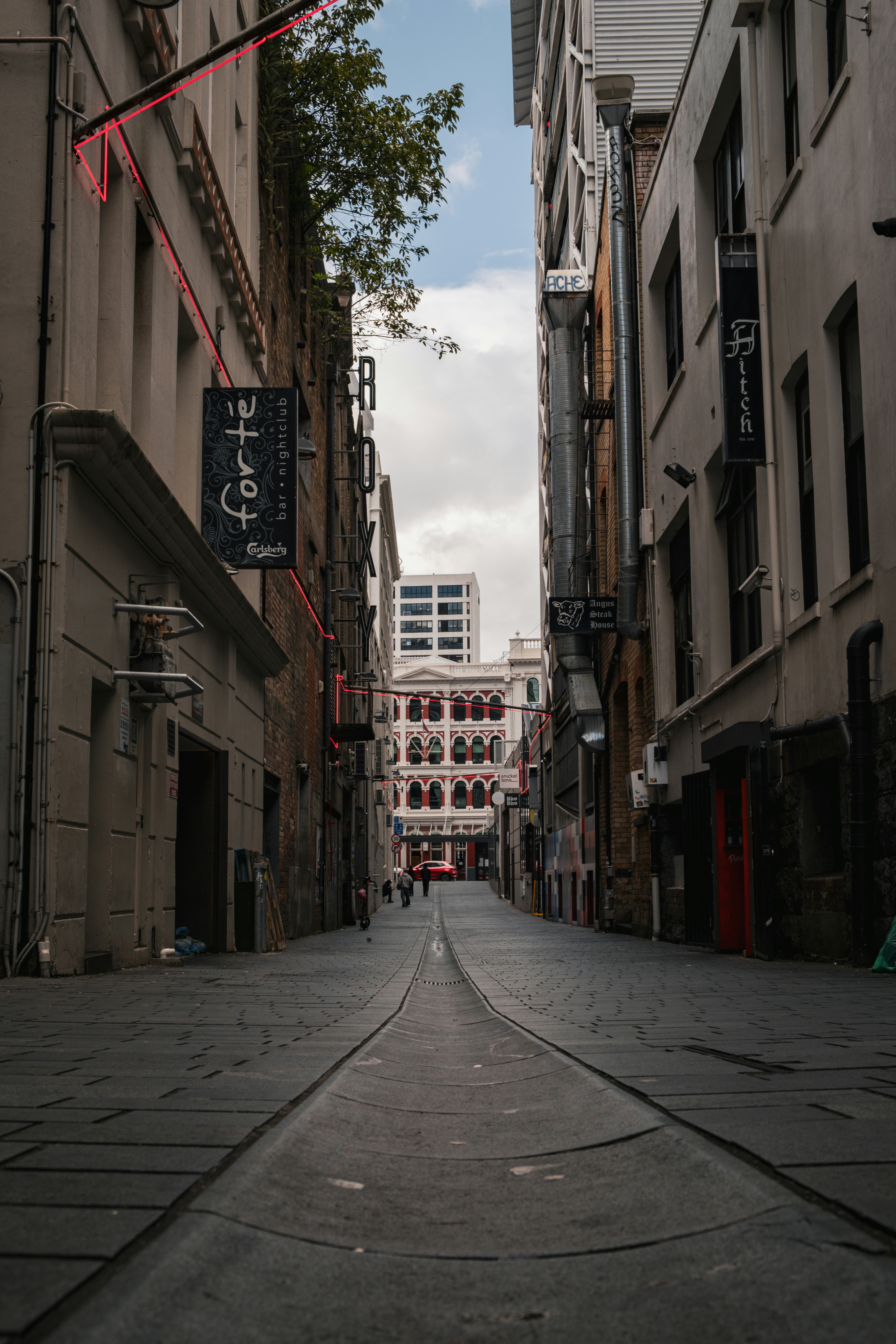 Empty city street with tram tracks and buildings.