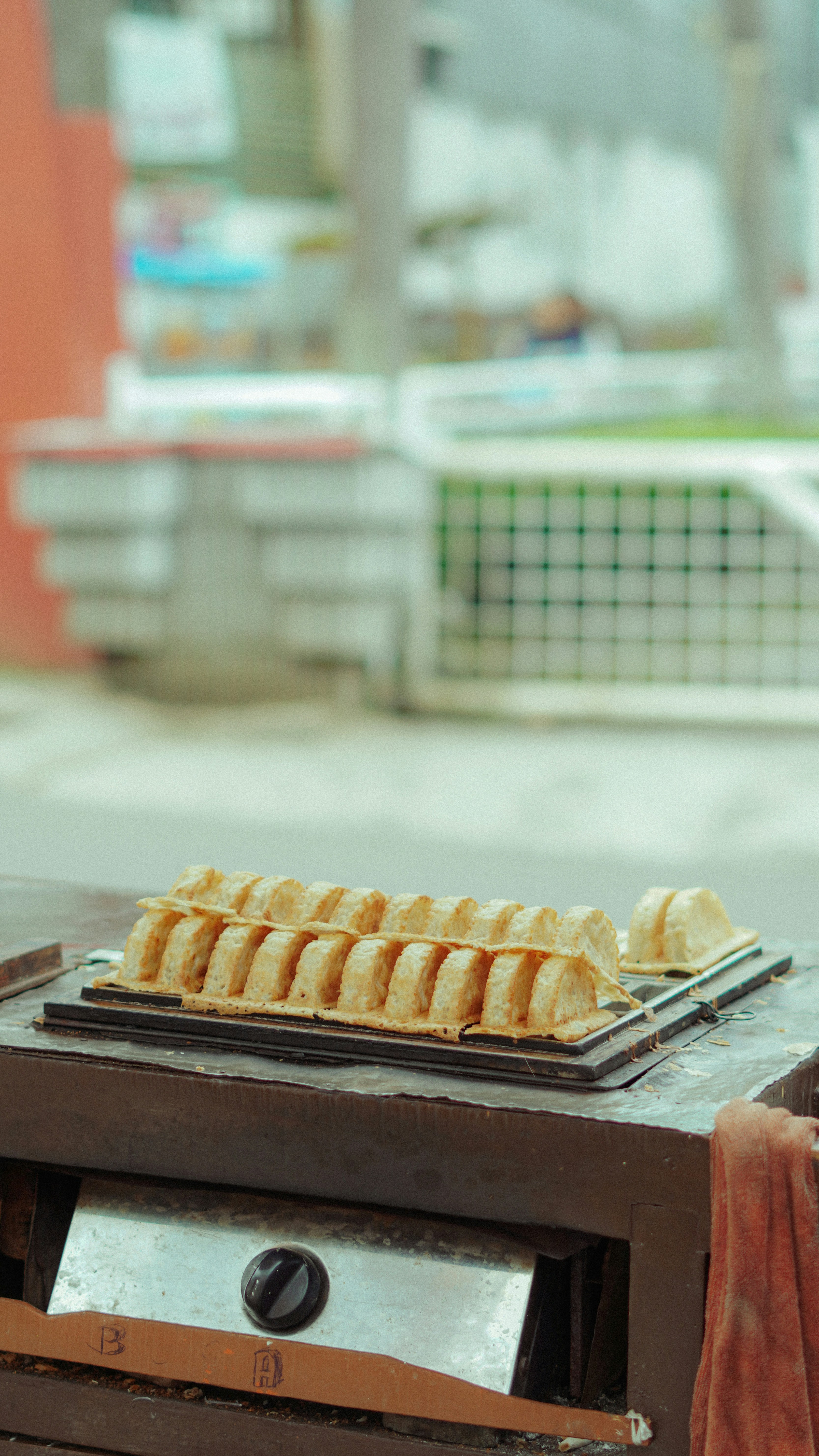 Row of golden baked goods on a metal tray.