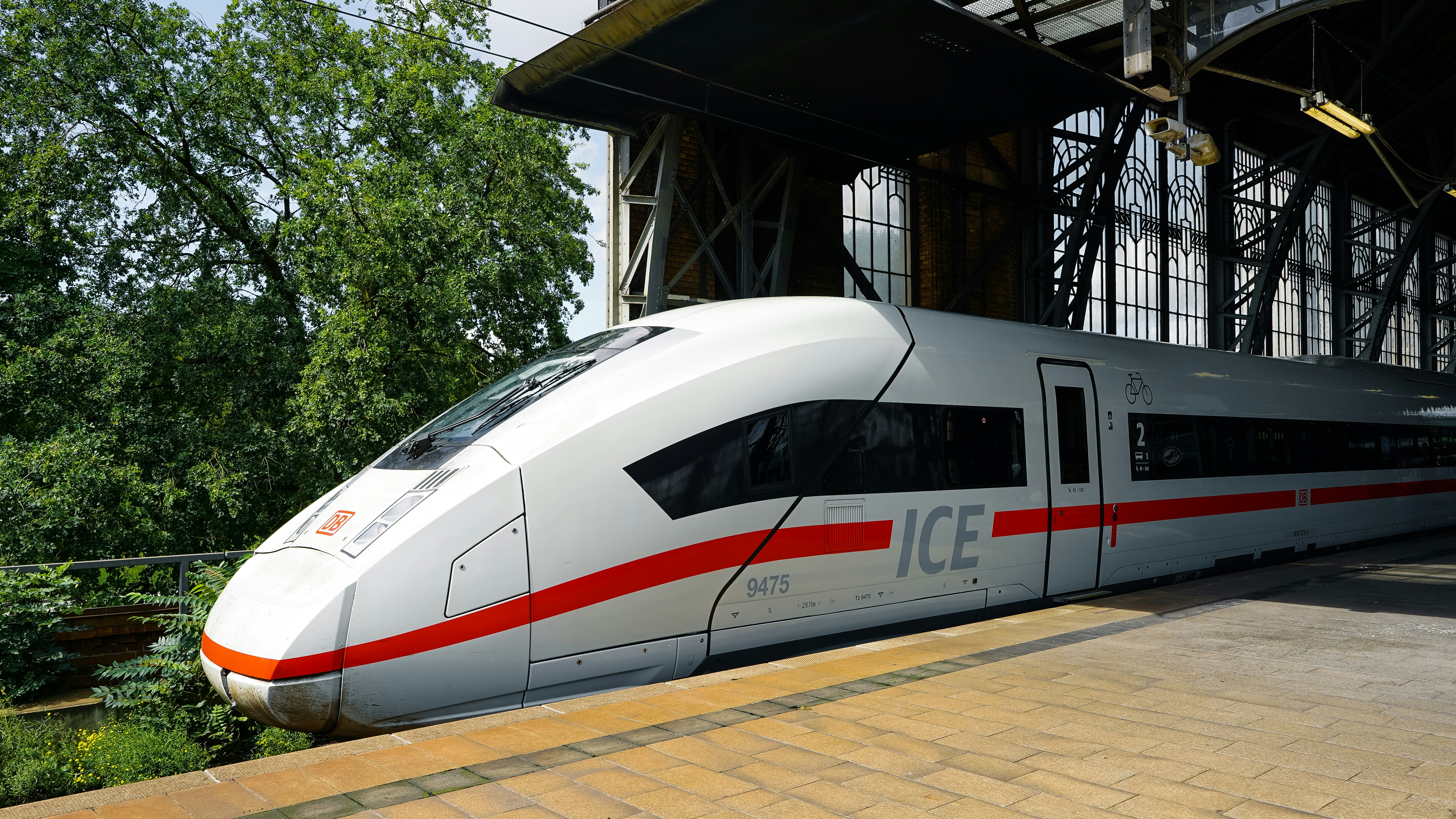 A white ice train with red stripes at station.