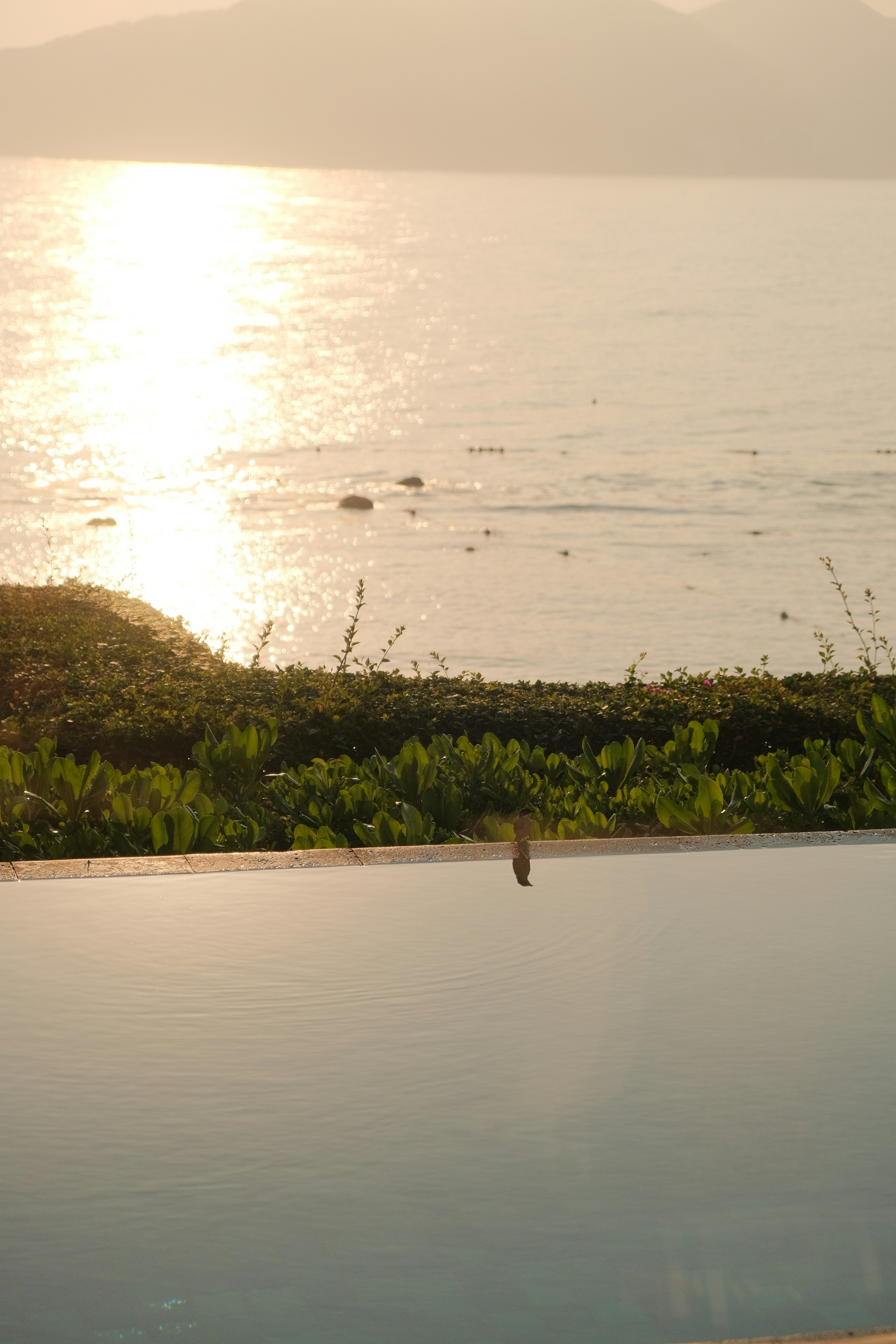 Sunset over the ocean with an infinity pool