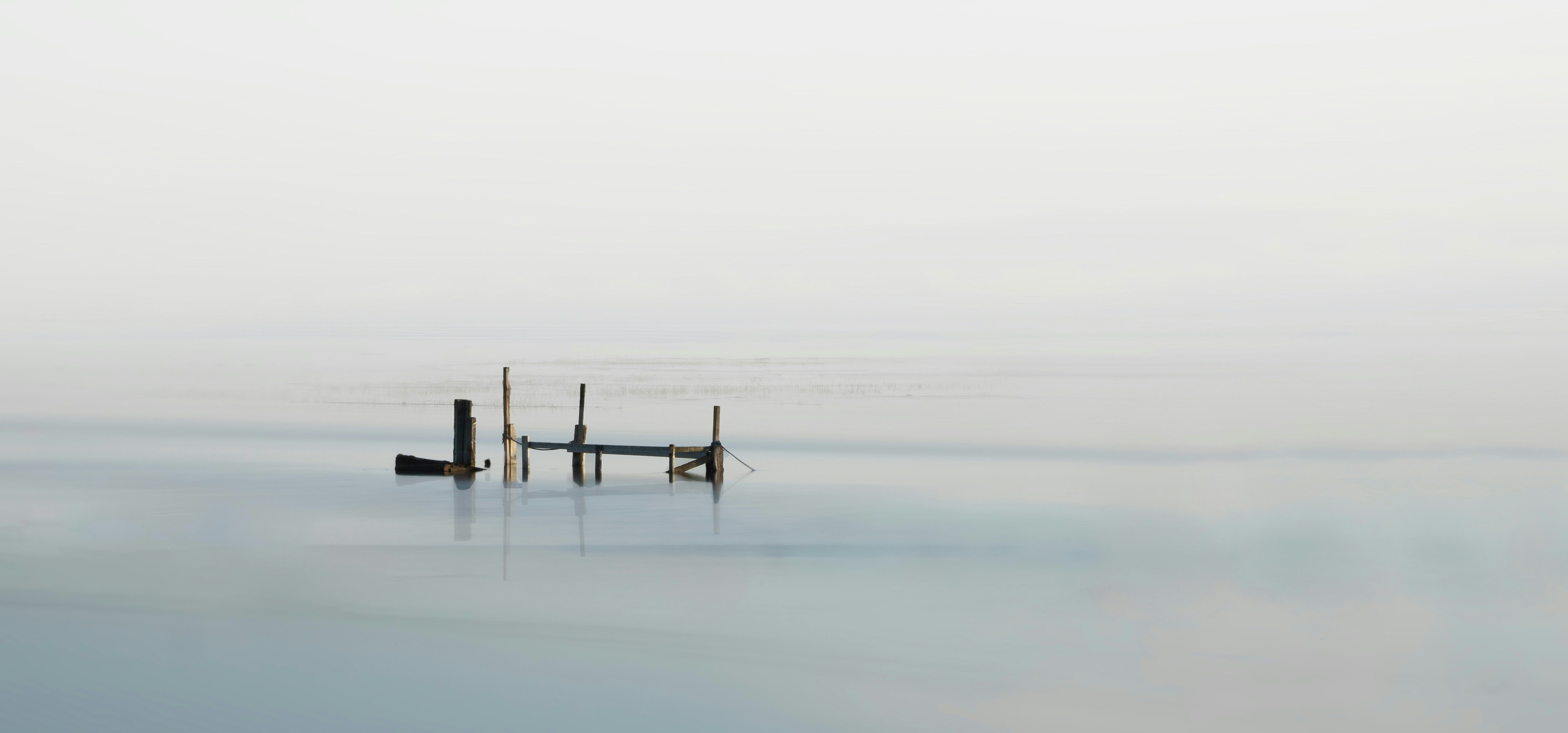 High water at Thornham | Old wooden pier posts in calm water