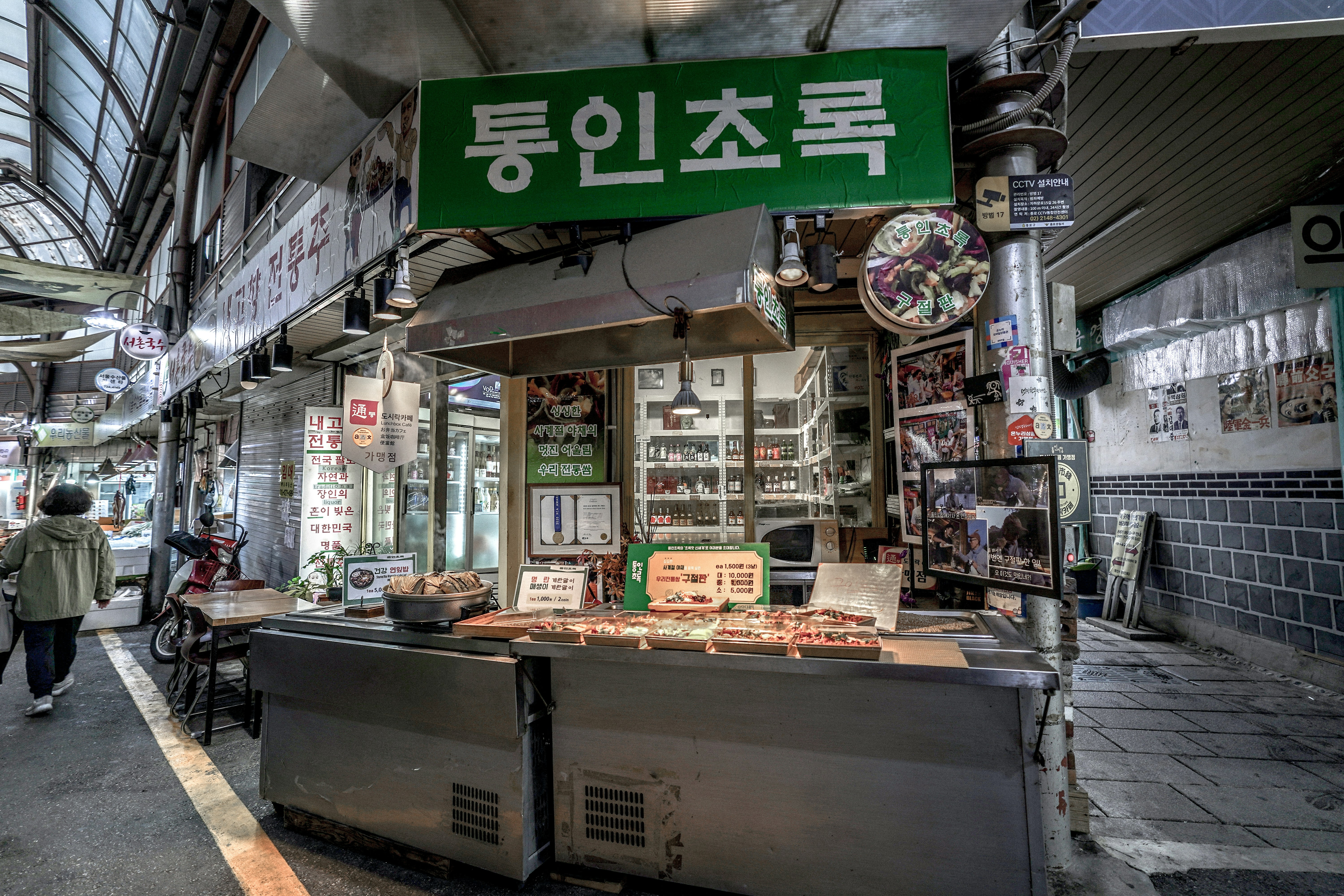 Small market stall with korean signage and english signs.