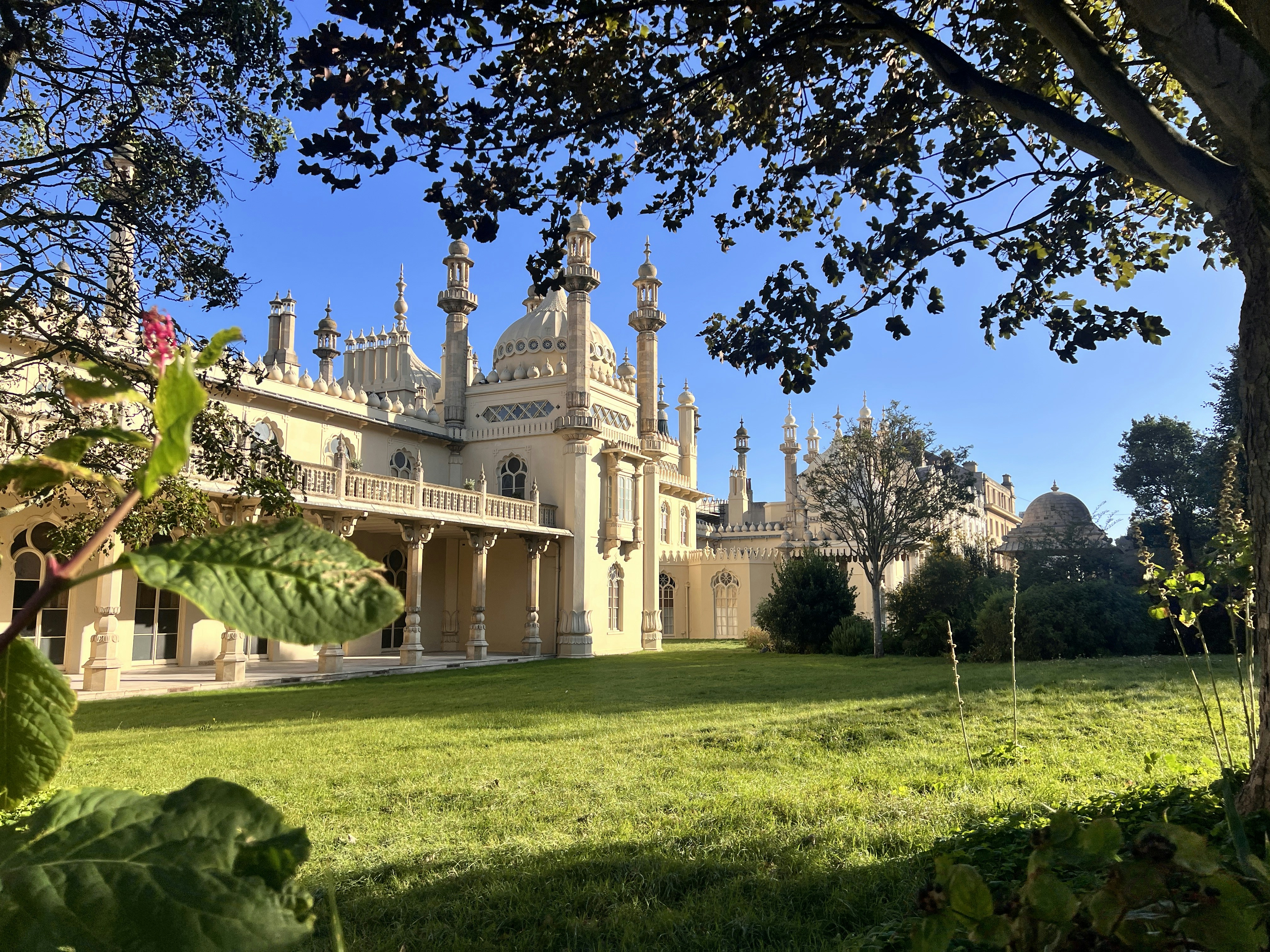Royal Pavilion Brighton, UK | Iconic Landmark. Brighton’s Royal Pavilion was built for King George IV and is one of Brighton’s top attractions and a must-see for visitors and tourists exploring the city. | Royal pavilion building with manicured lawn and trees