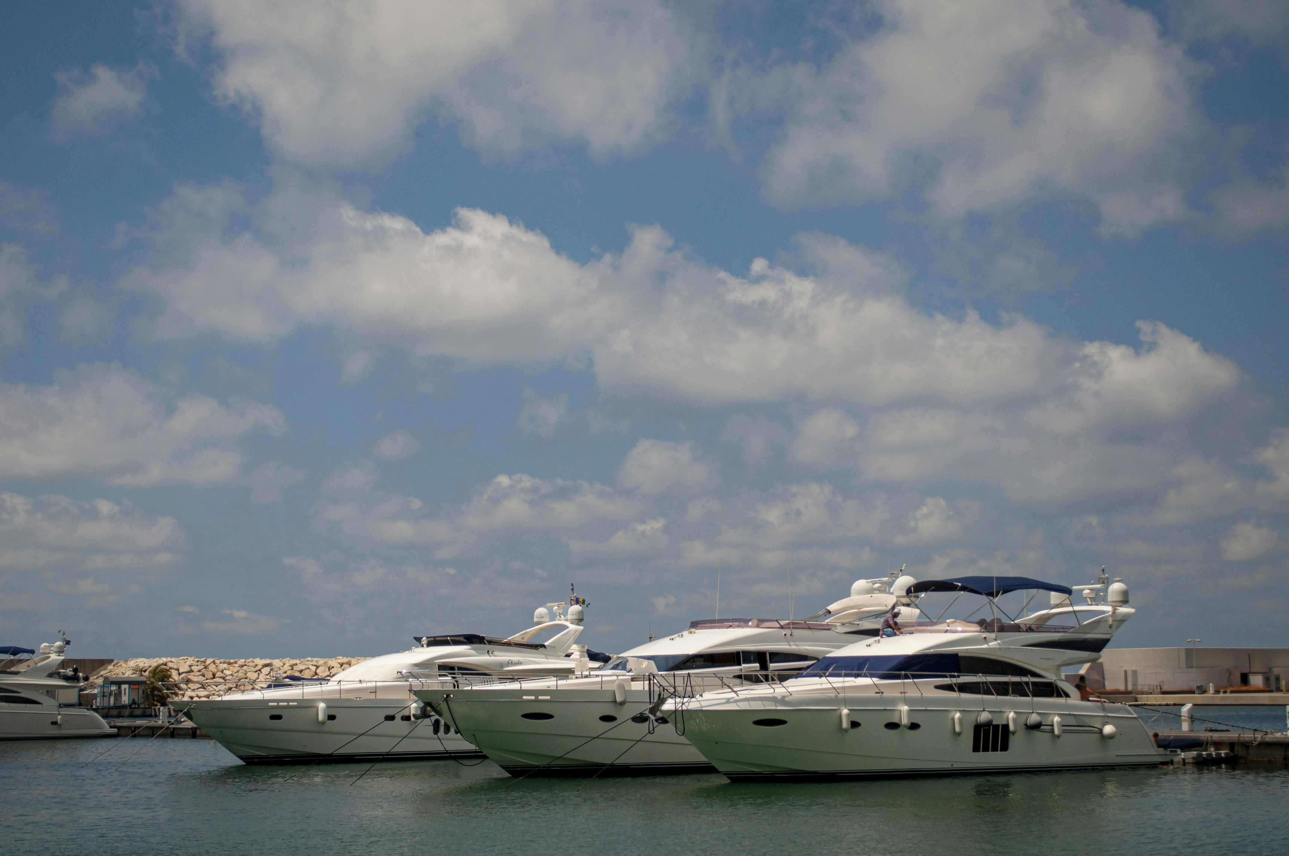 In the sunny Bey, Boats fill the sea. | Luxury yachts docked in a marina under blue sky.