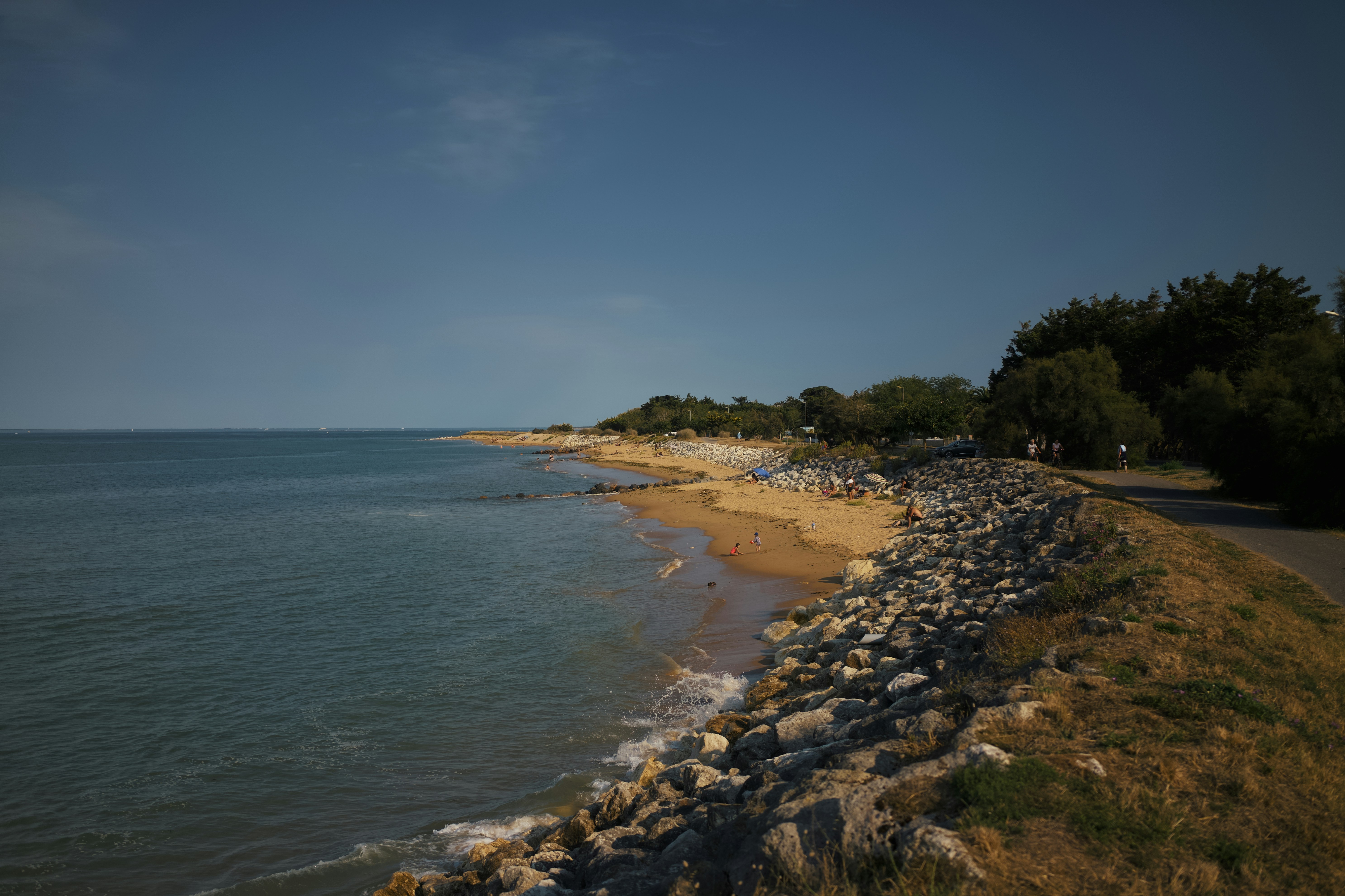 Sandy beach with rocky shoreline and calm ocean waves