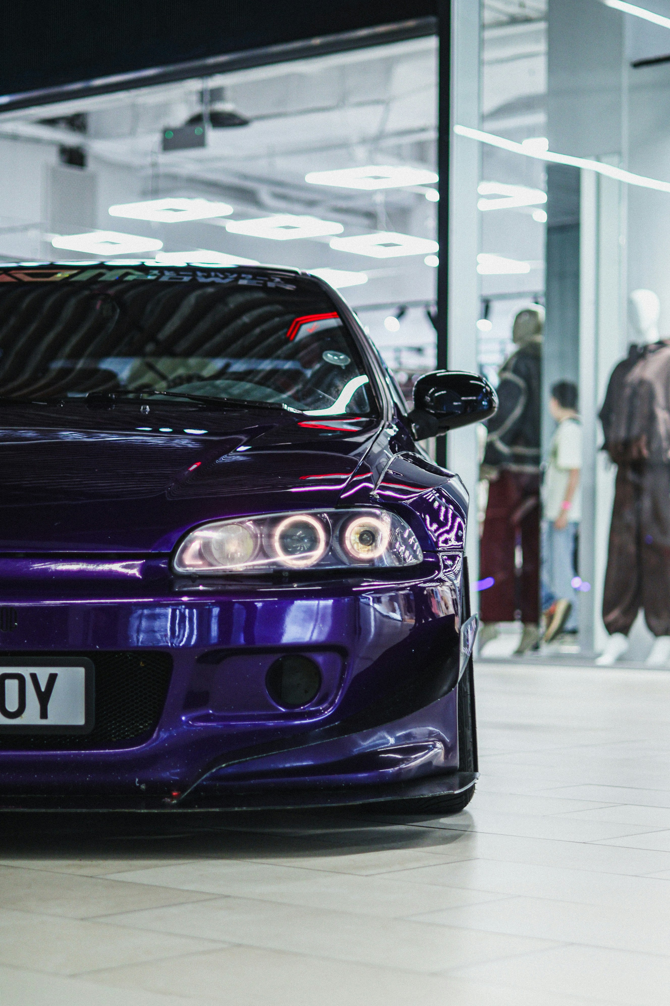Neon-Gloss Frontal: A Purple Showroom Sports Car in Focus