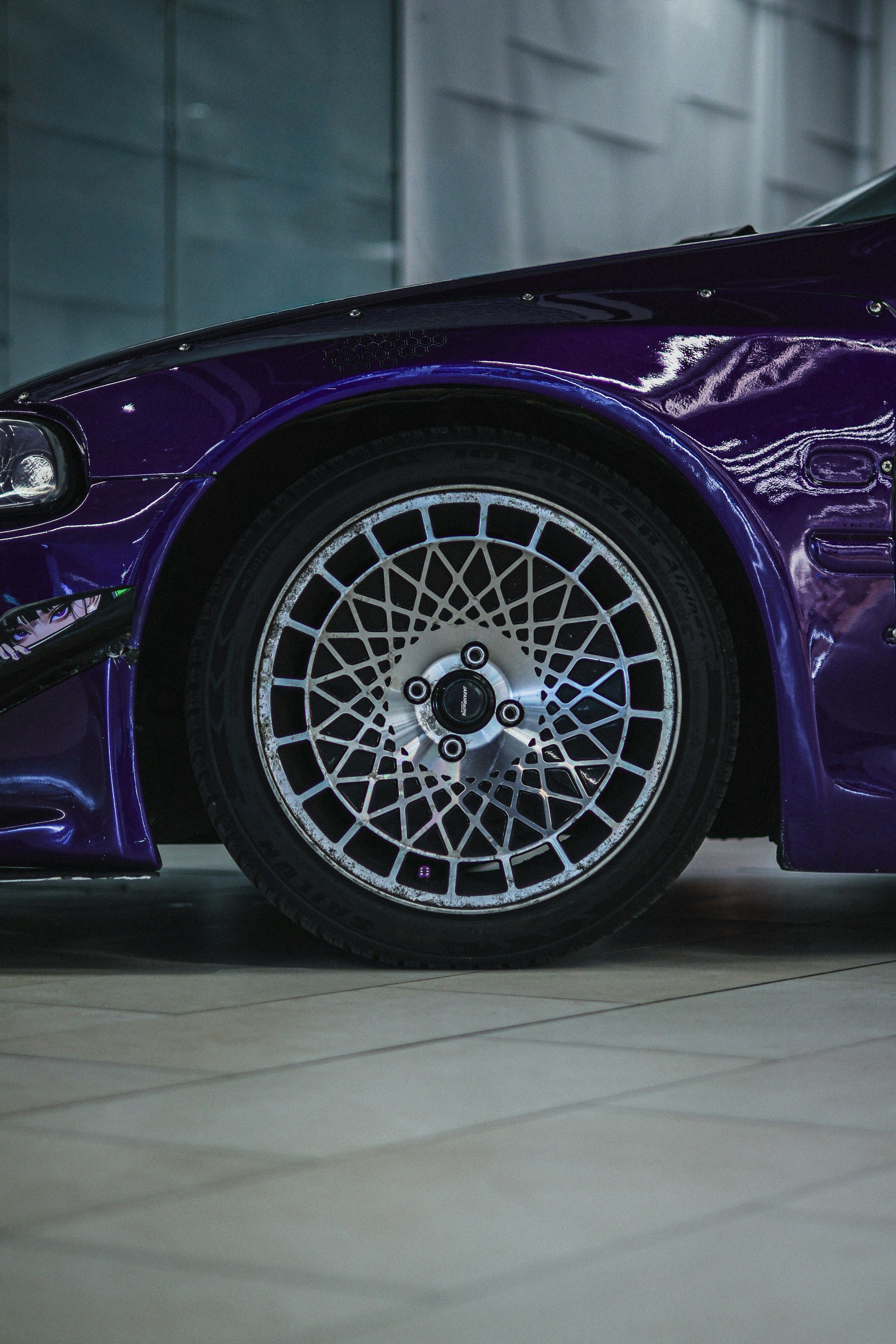 Close-up of a purple car's custom wheel.