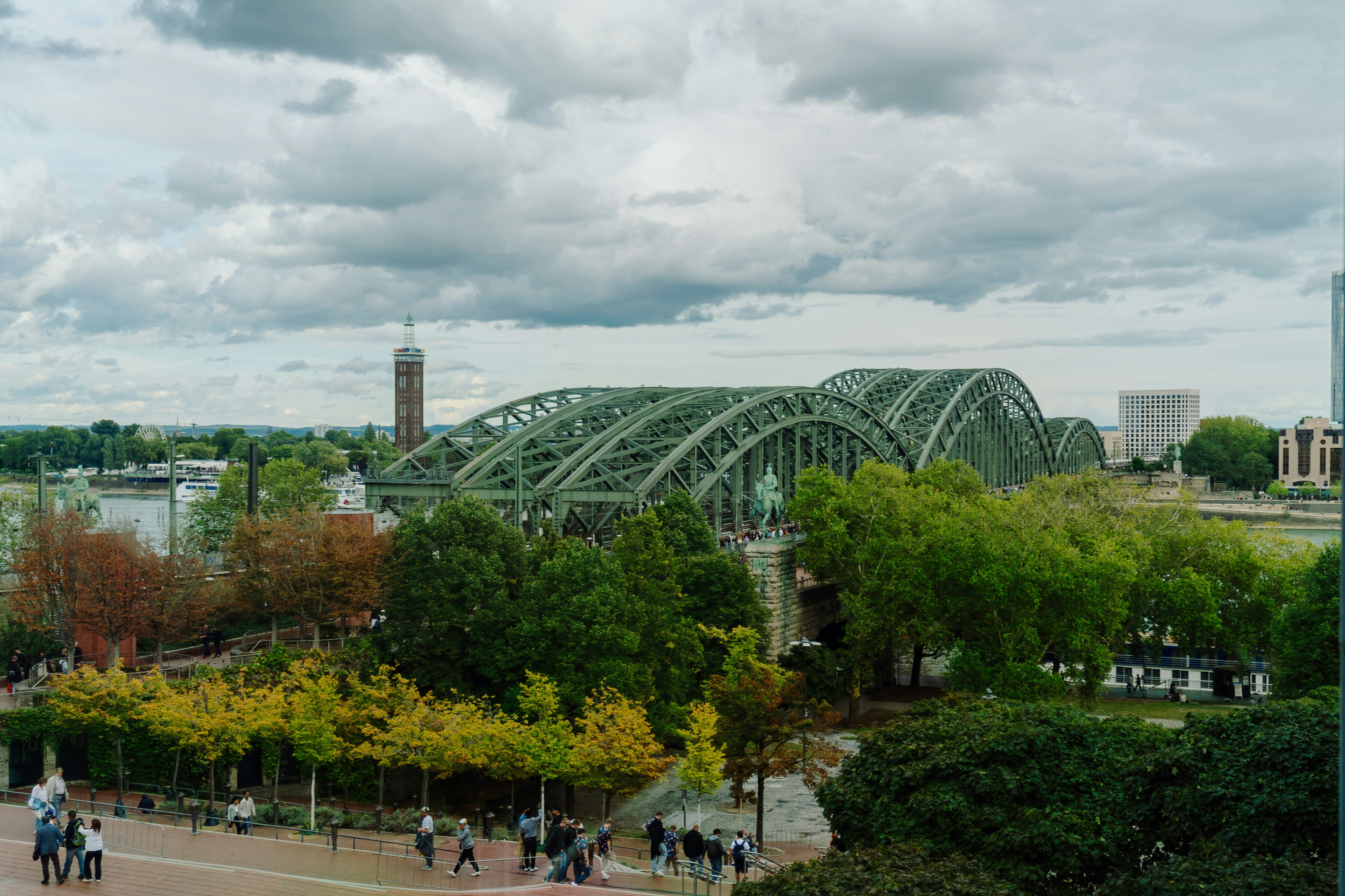 Green arched bridge over a river with trees