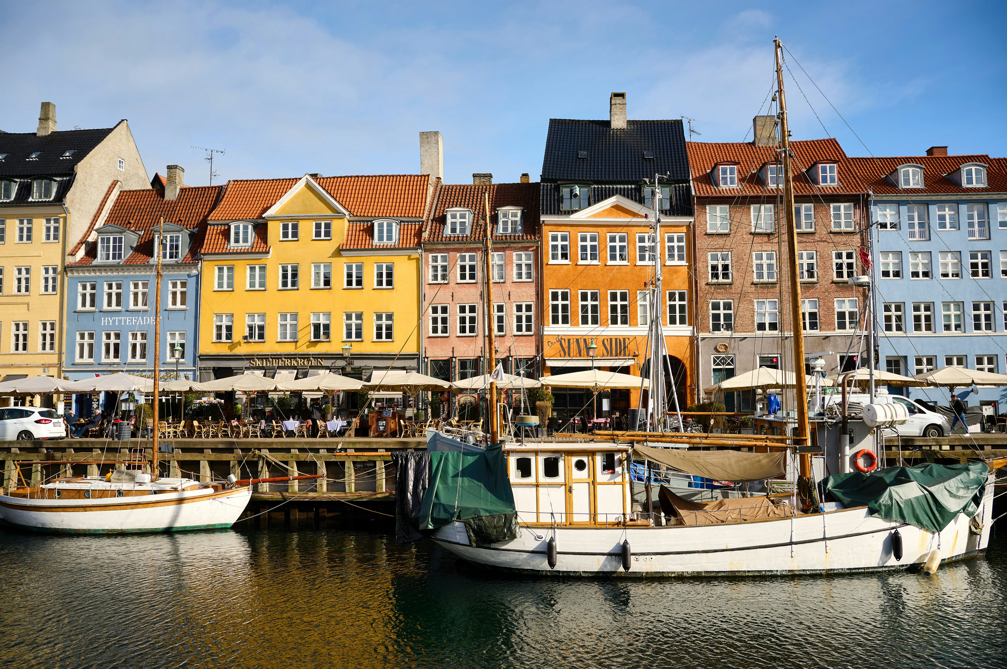 follow me on Instagram greg_pix_25 | Colorful buildings line a canal with boats and cafes.