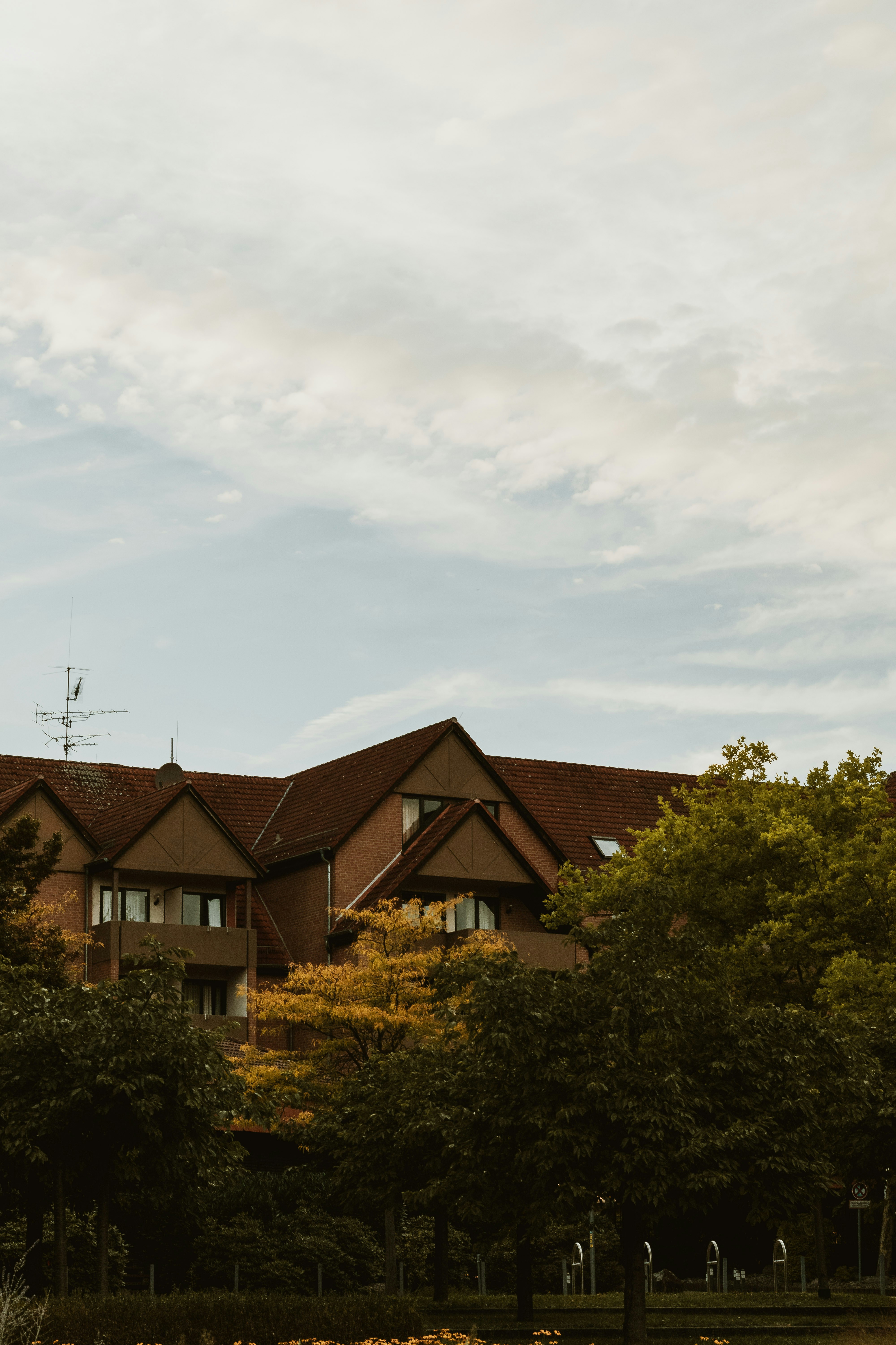 Building with red roof behind green trees