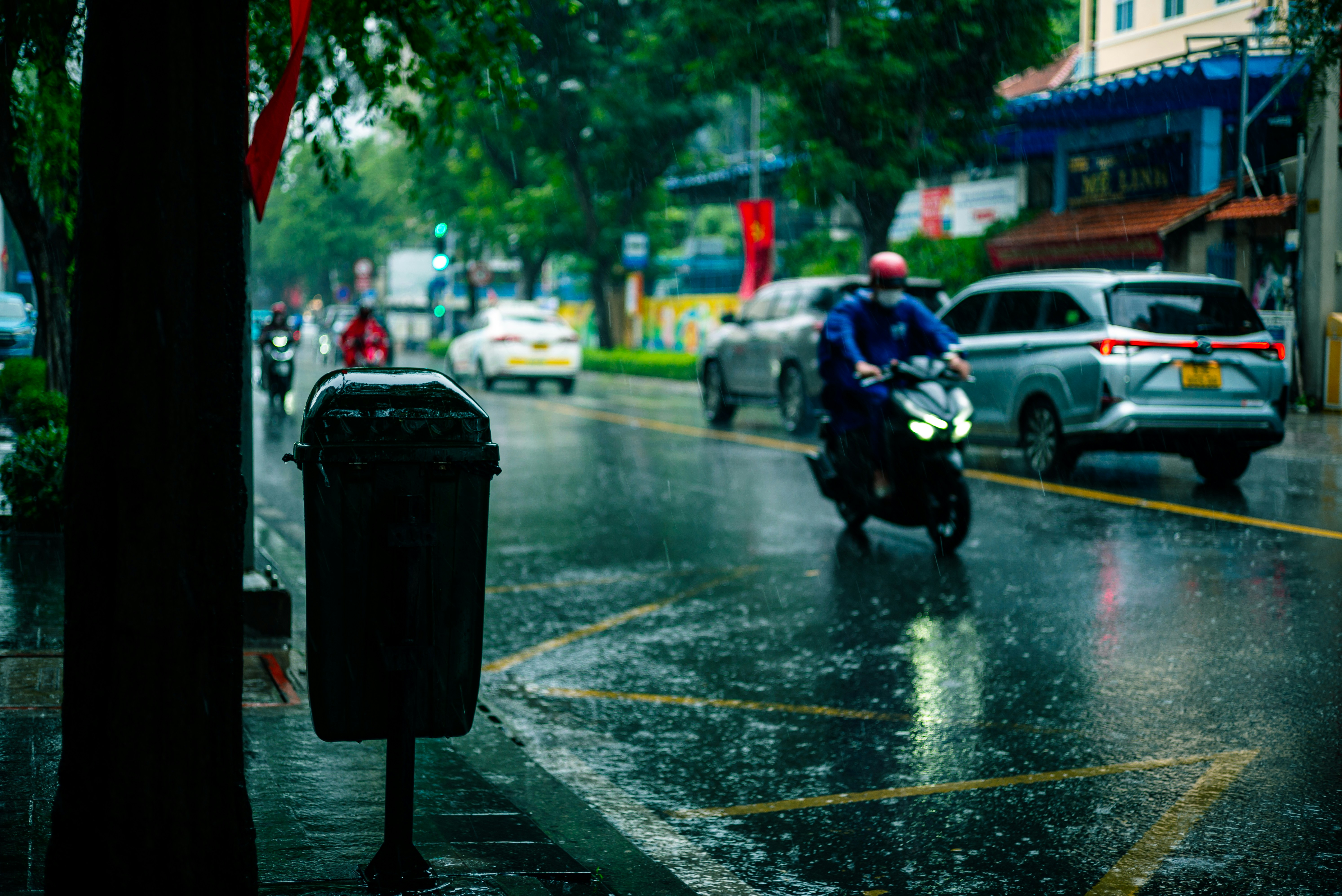 Motorcyclist rides on wet street during rain