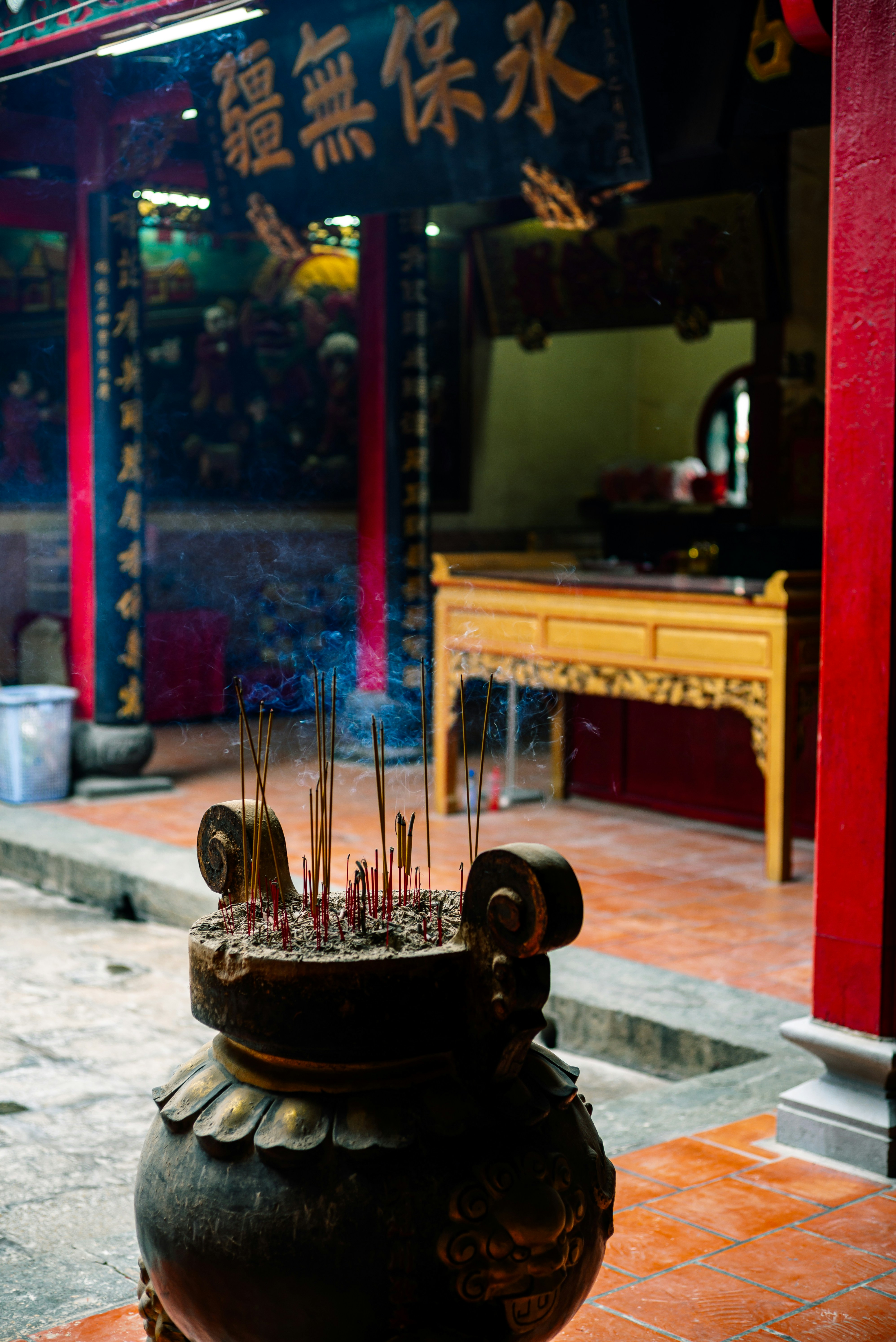 Incense sticks burning in a traditional temple urn.