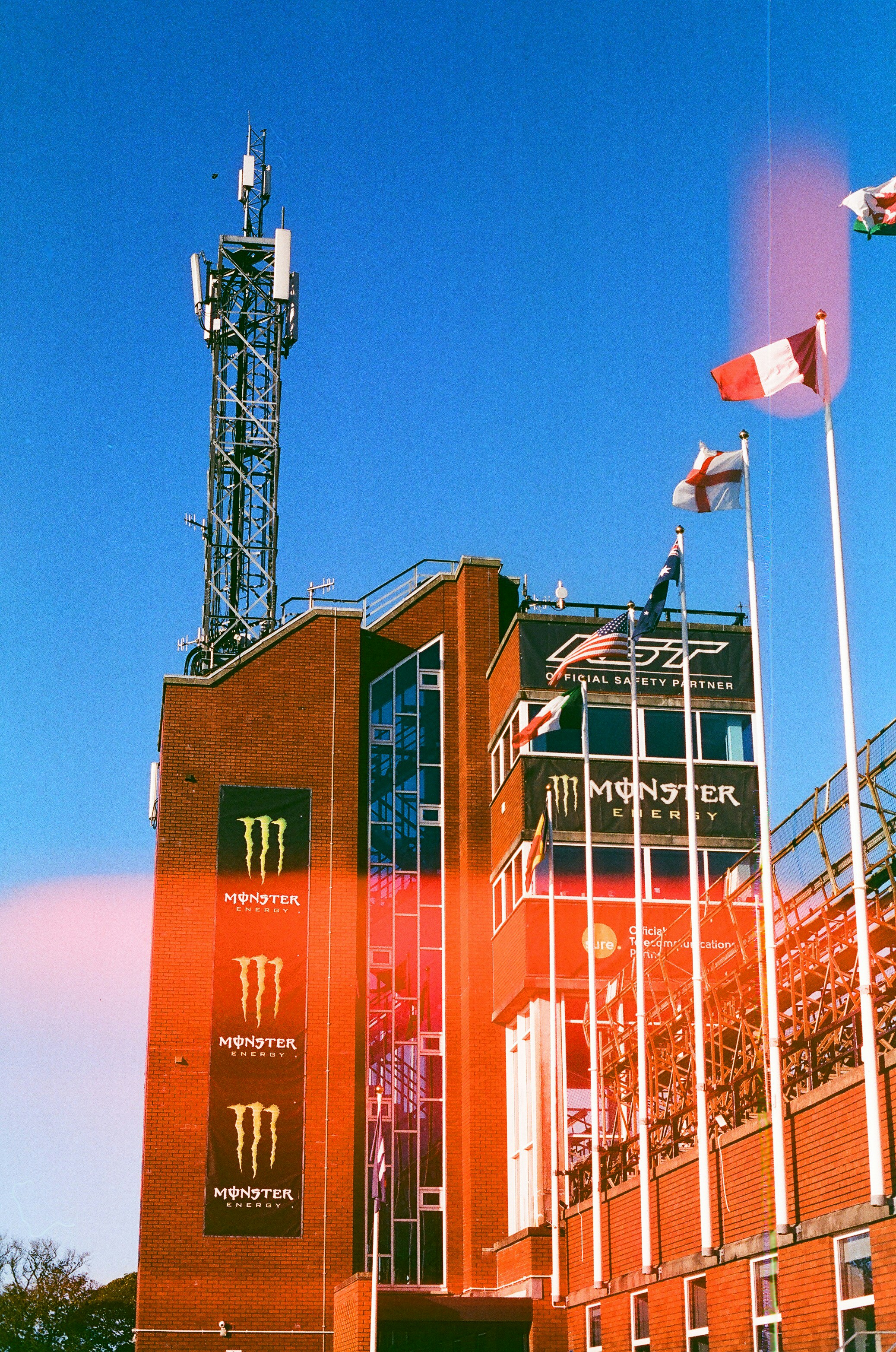 Brick building with cell tower and flags under blue sky. photo – Free ...