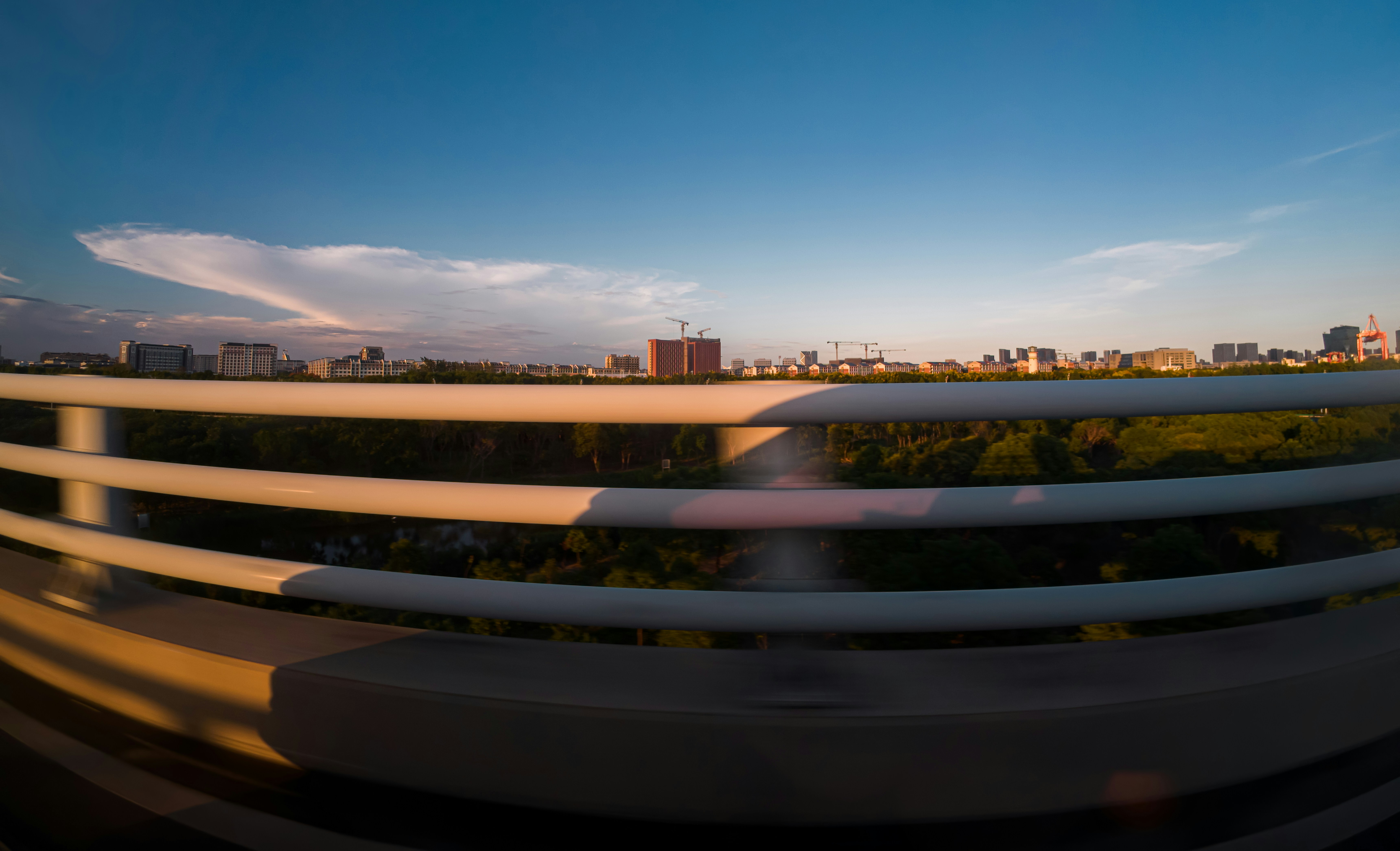 City skyline seen from a bridge at sunset.