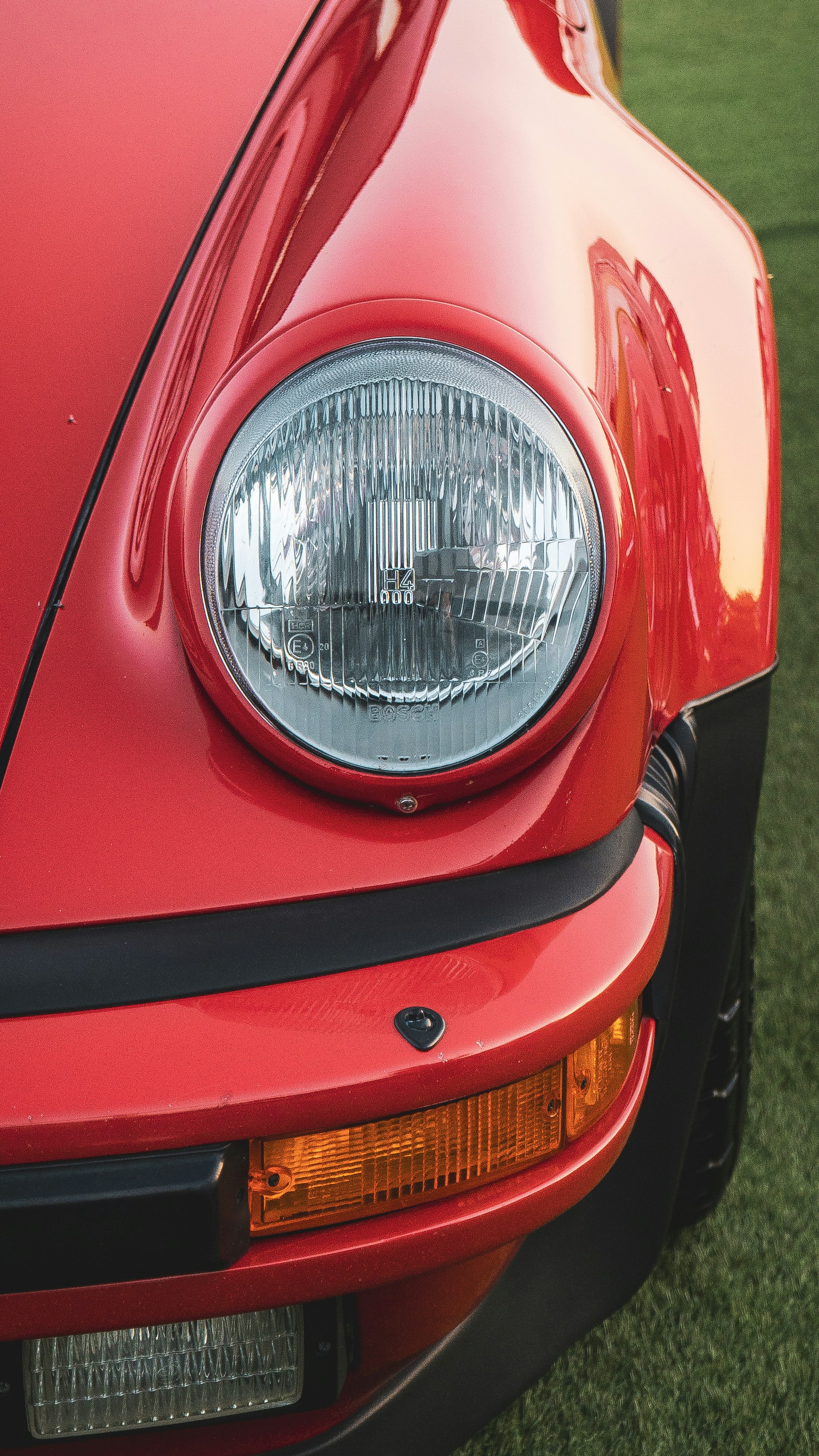 Close-up of a red vintage car's headlight.