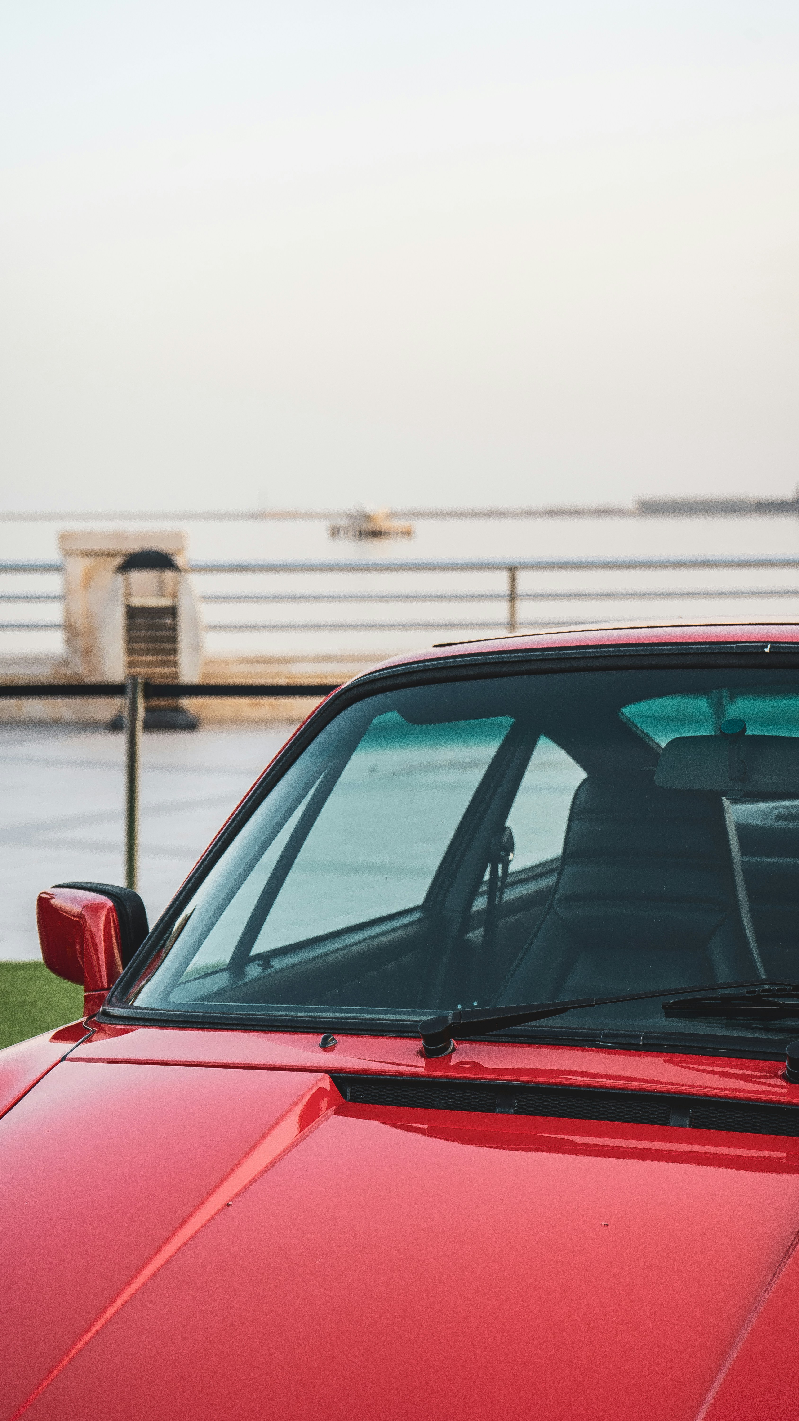 Red sports car parked by the water
