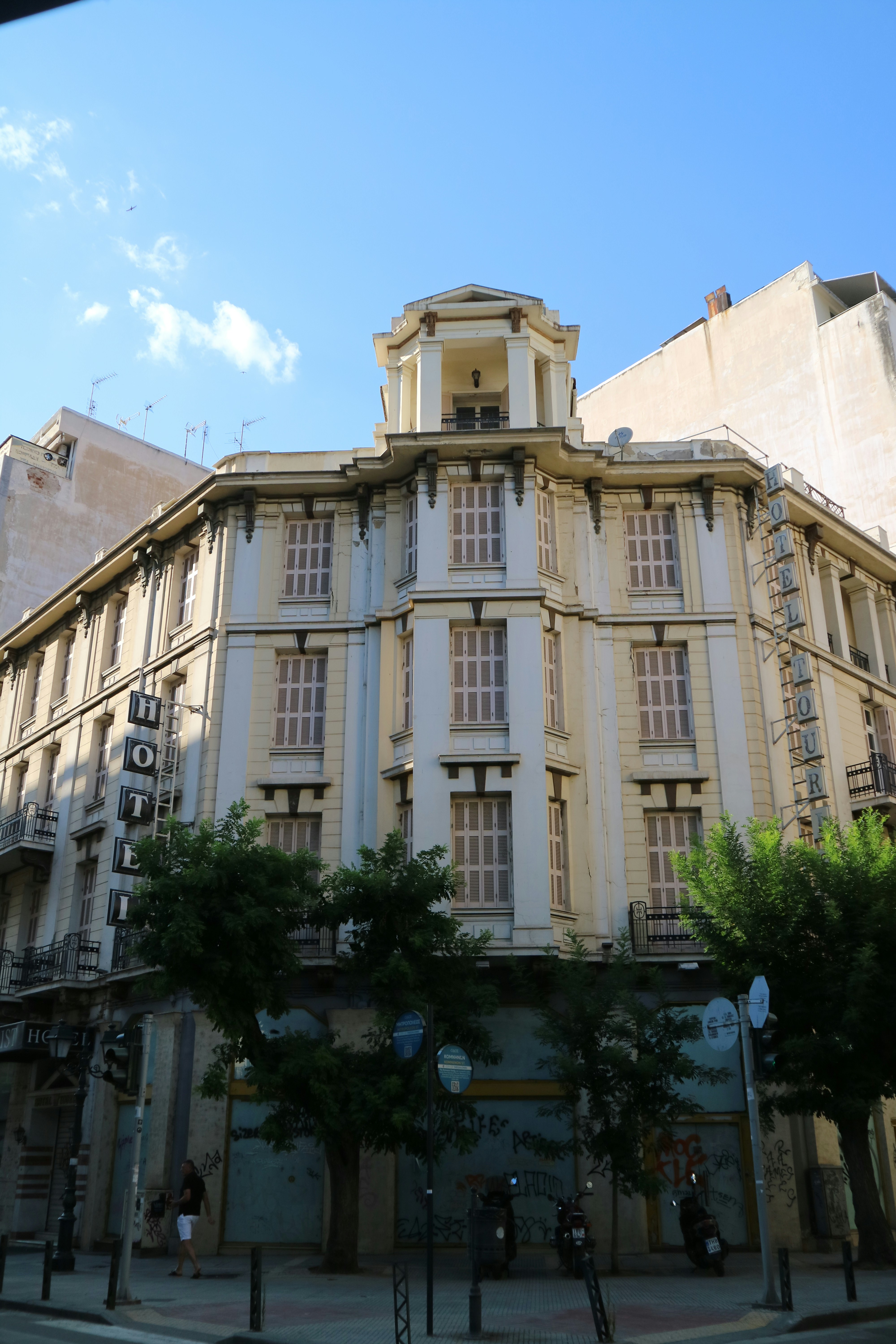 Ornate hotel building with closed shutters under blue sky
