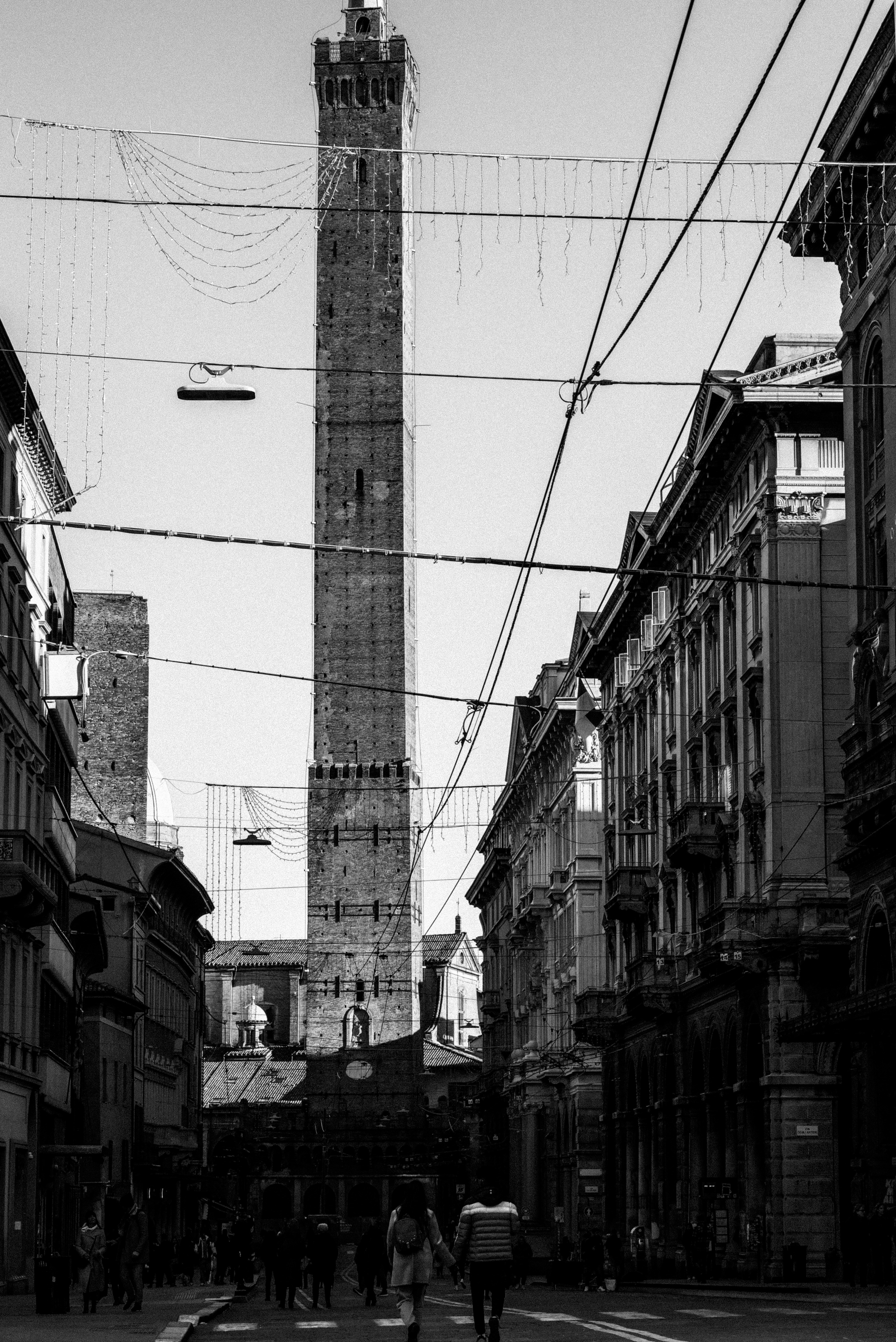 Tall historic tower overlooking a city street.