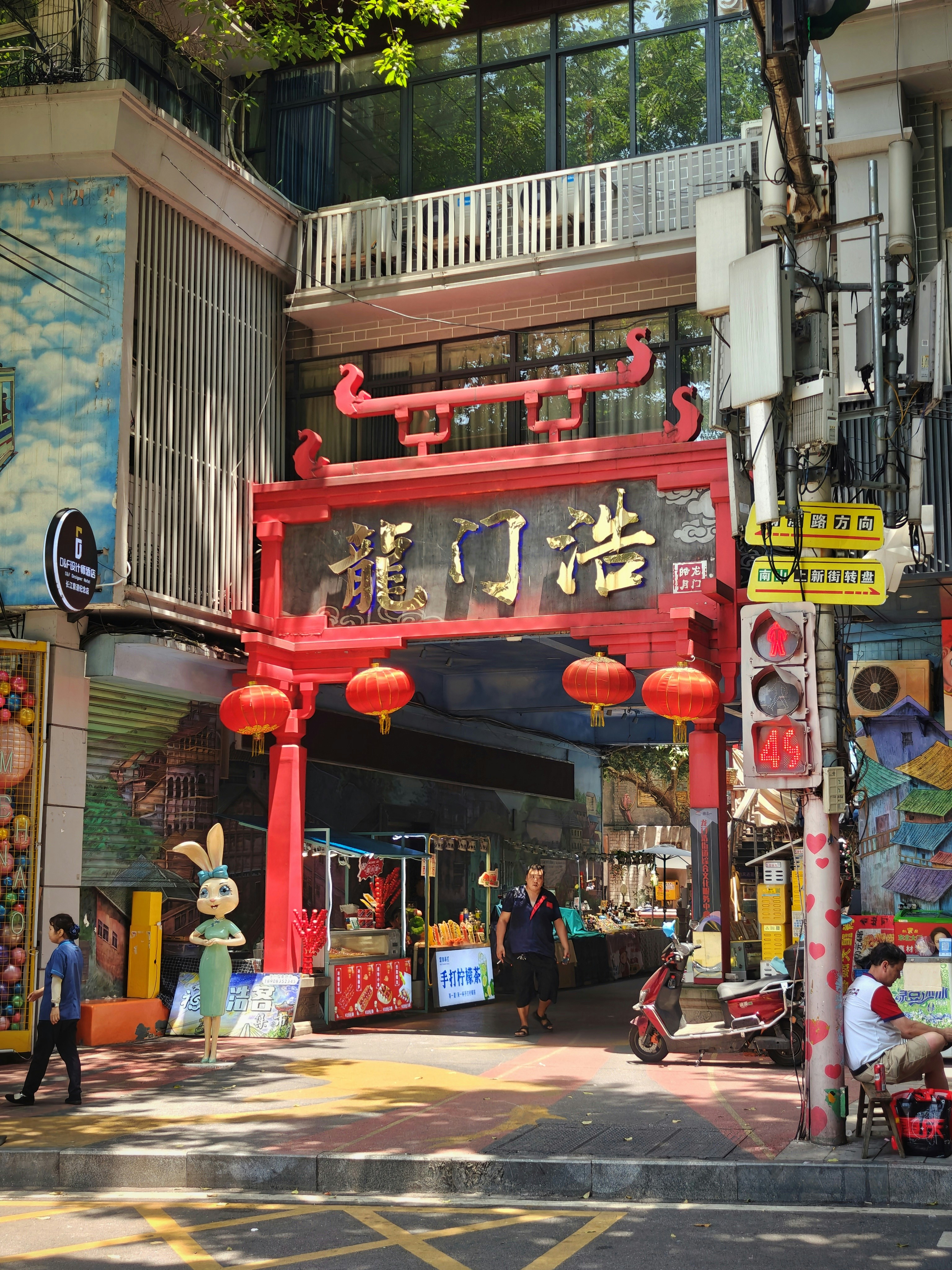 Streets in Chongqing. | Traditional asian archway with market stalls and people.