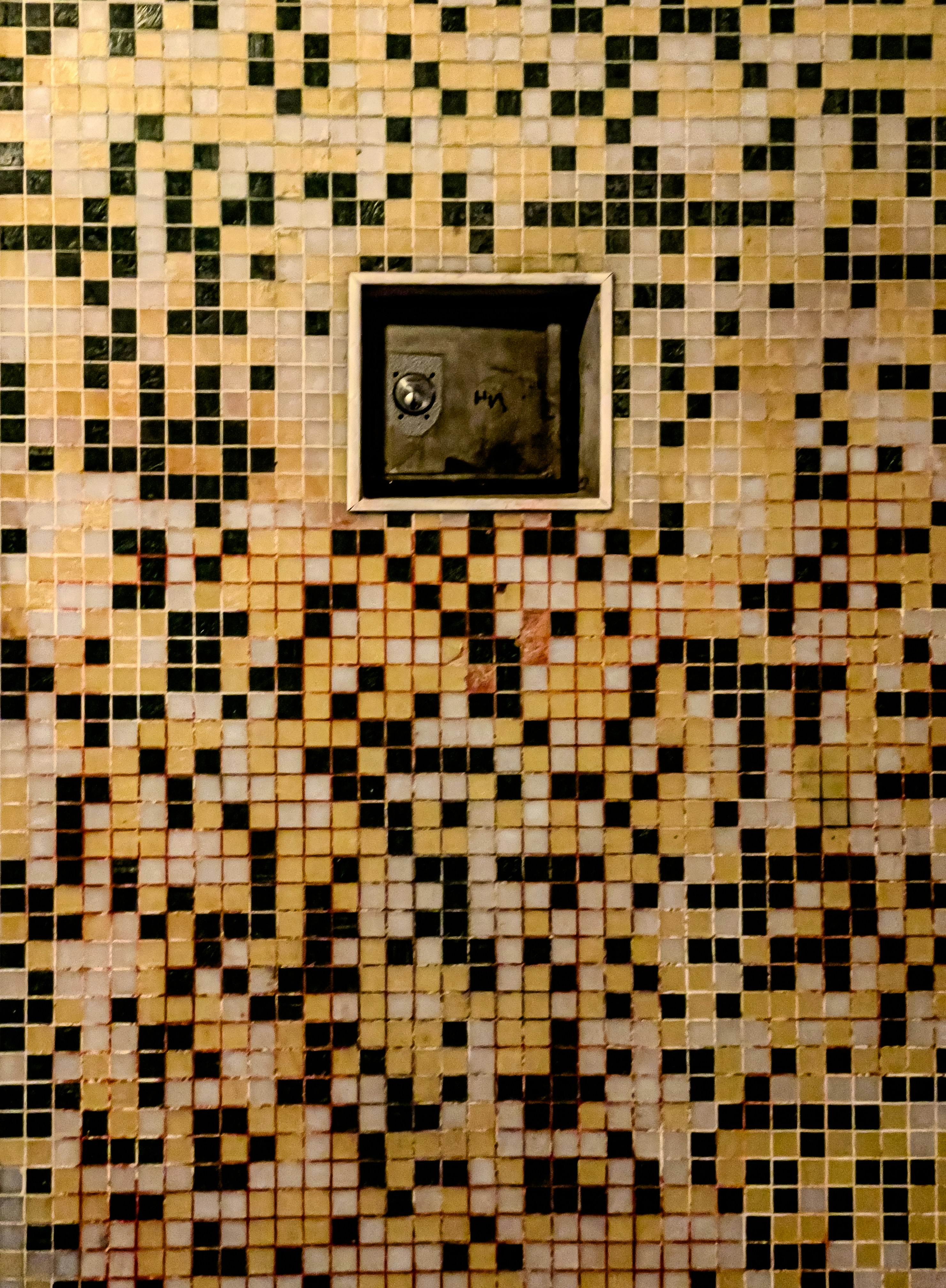 Mosaic tile wall with a recessed square niche.