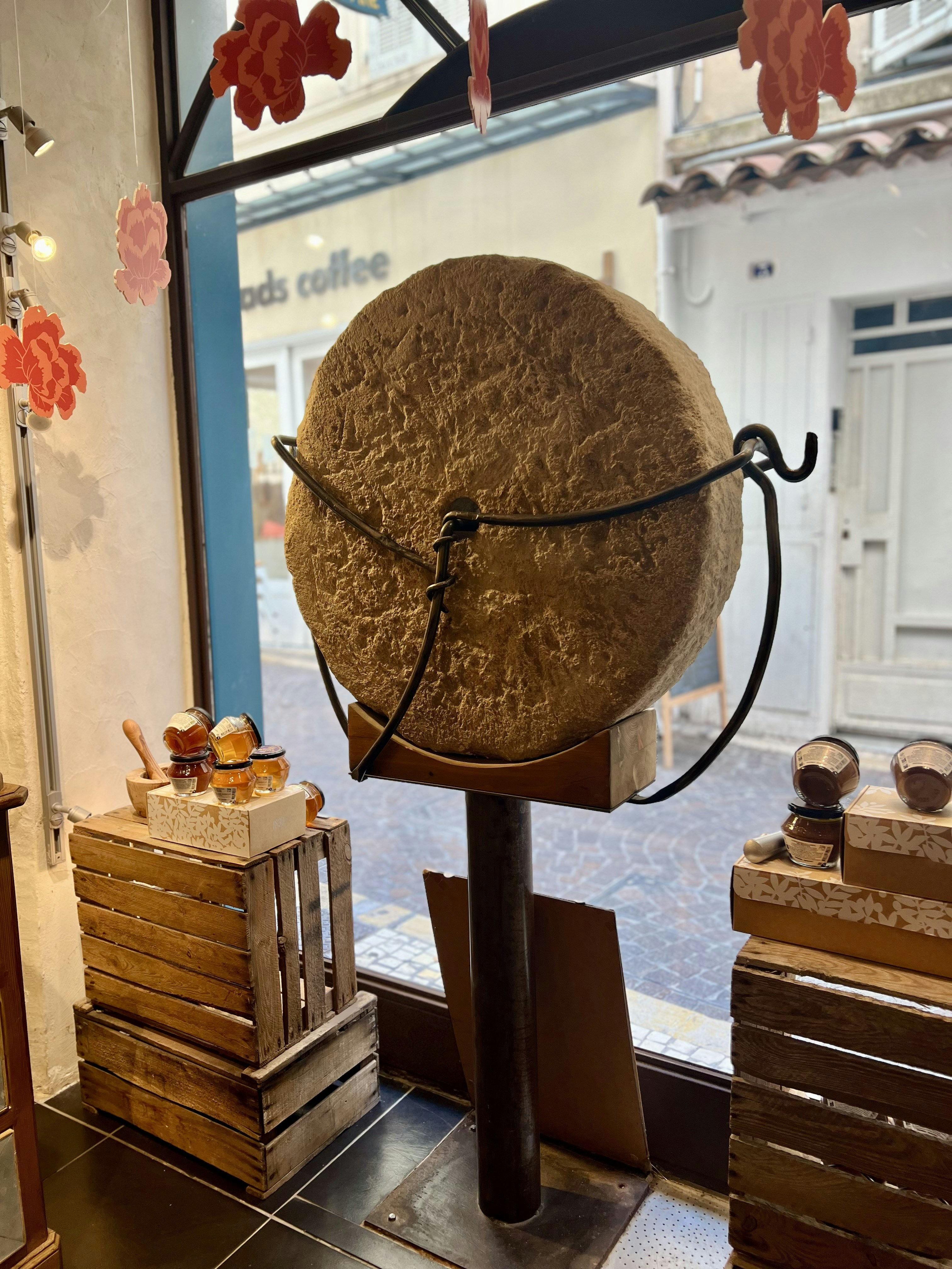 Large stone wheel on display with decorative items.