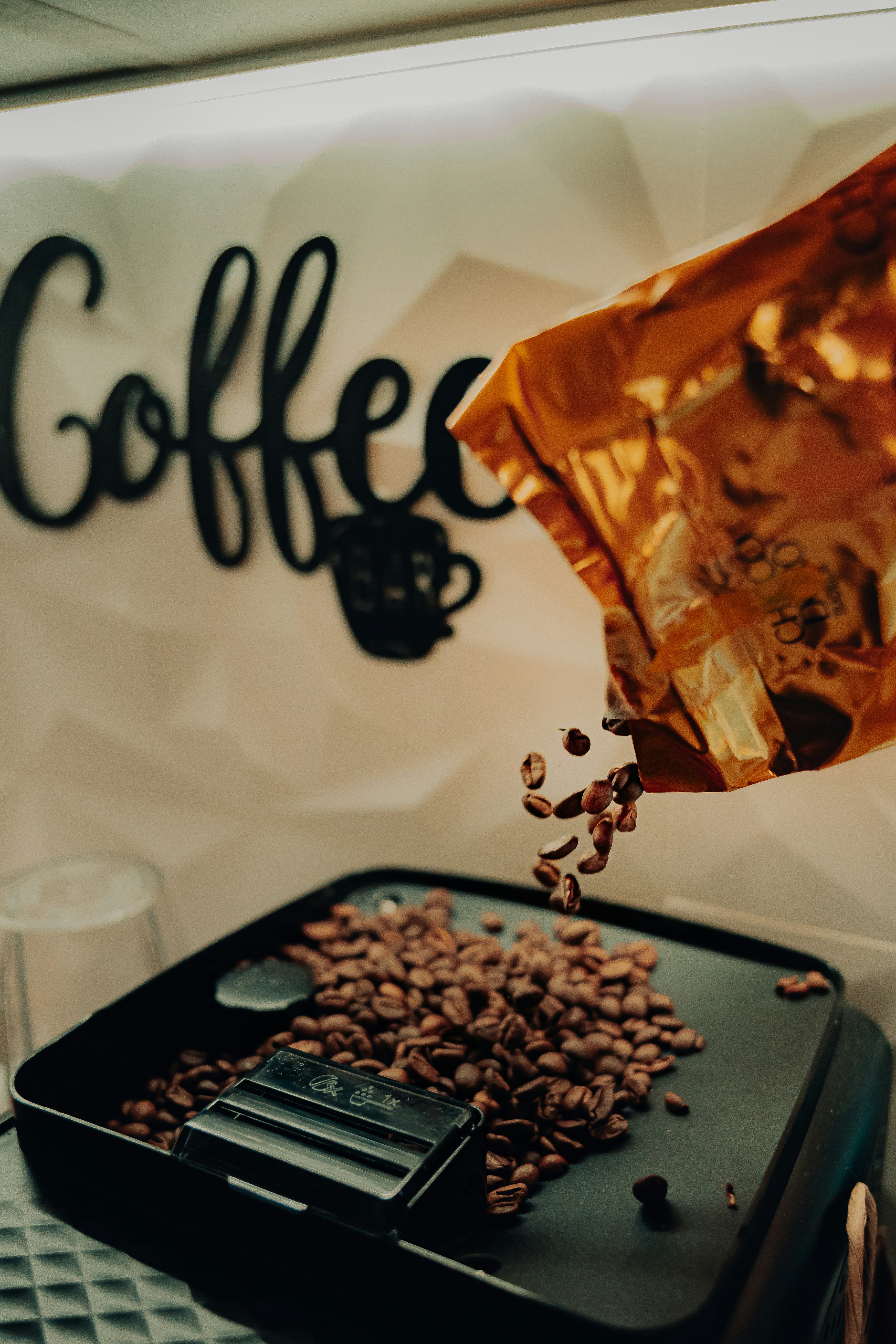 Bean Cascade into a Gleaming Tray Under Amber Café Light