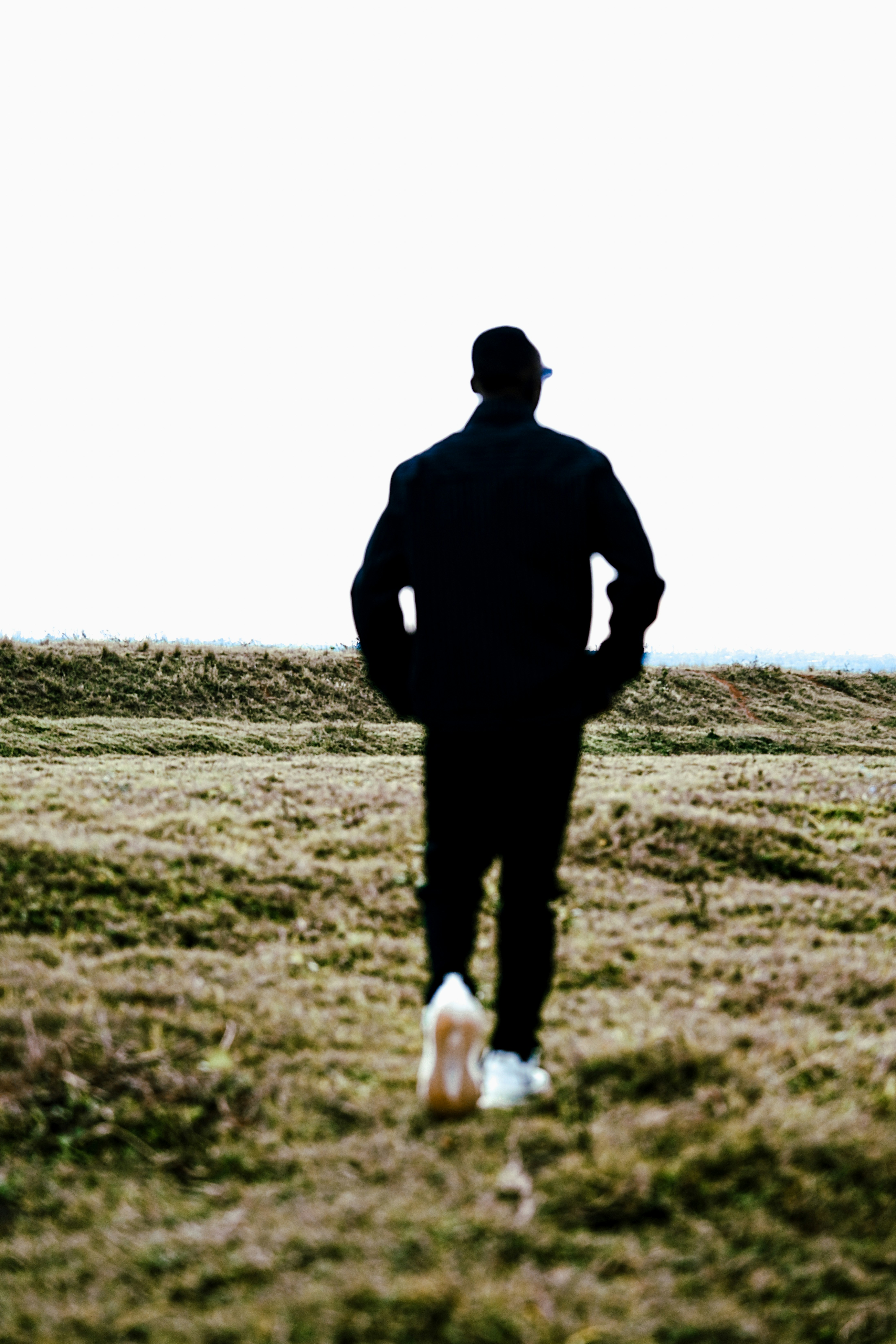 Blurry concept only make sense when ones identify him with nature connectedness and turns his back to the negative | Man walking away in a grassy field