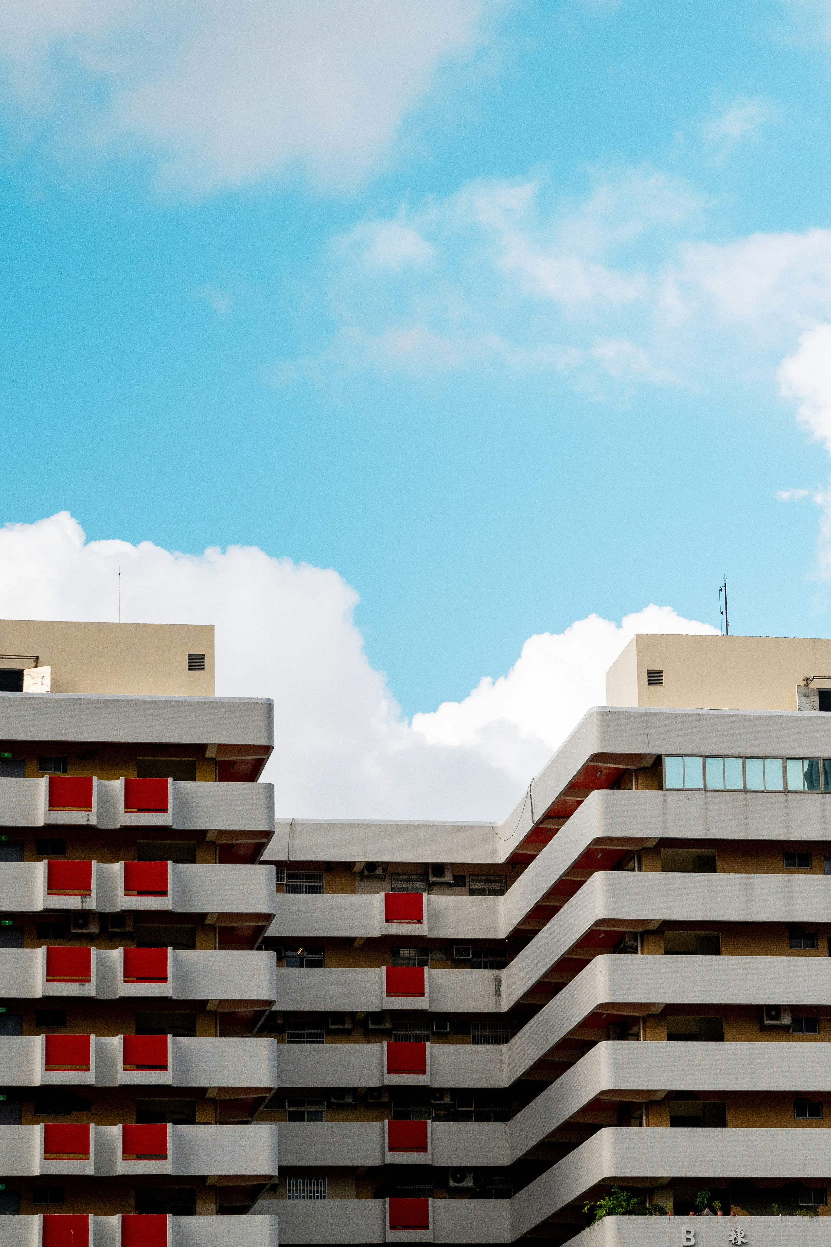 Modern apartment buildings with red accents under blue sky