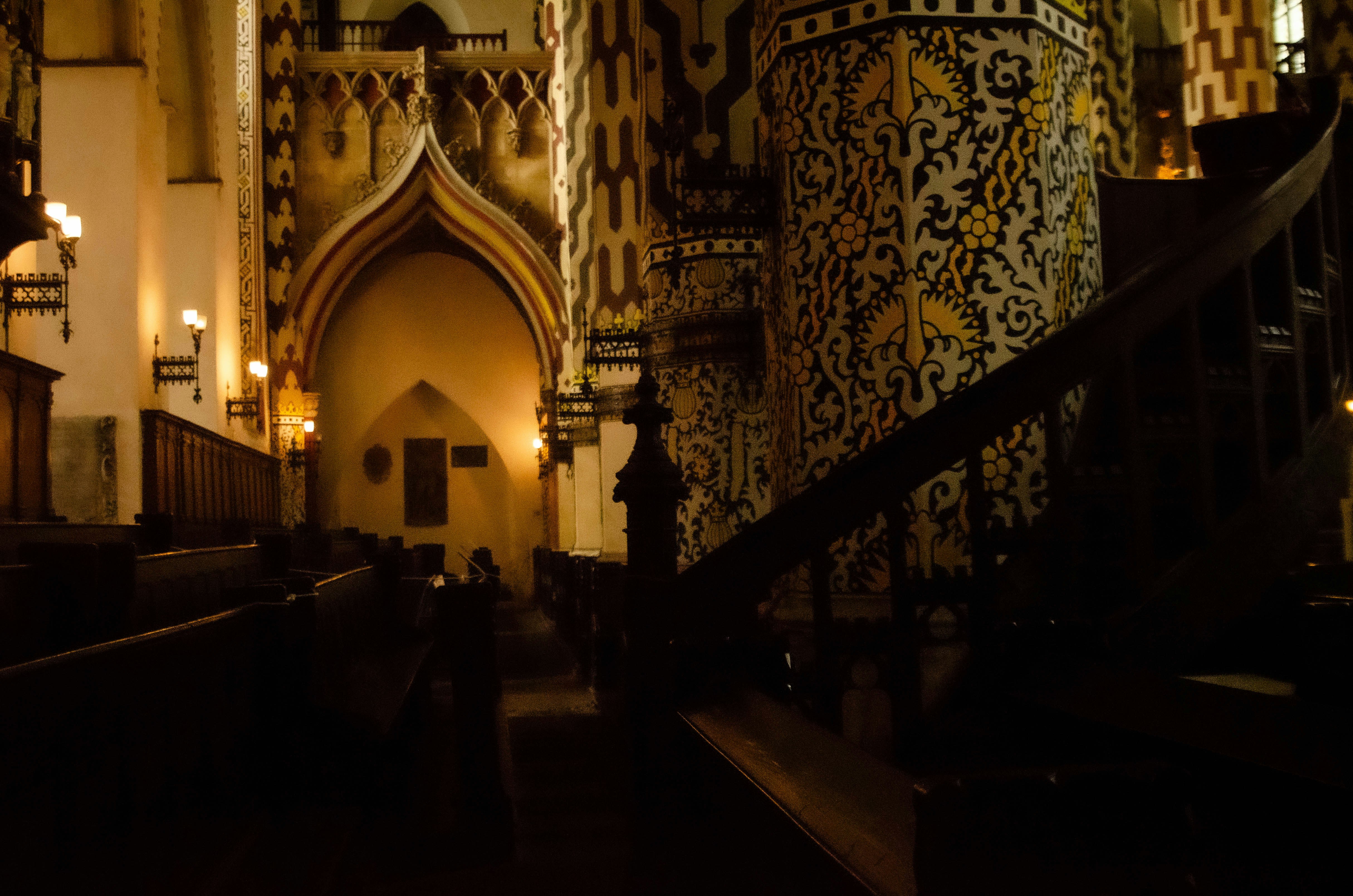 Interior of a dimly lit, ornate cathedral with patterned columns.