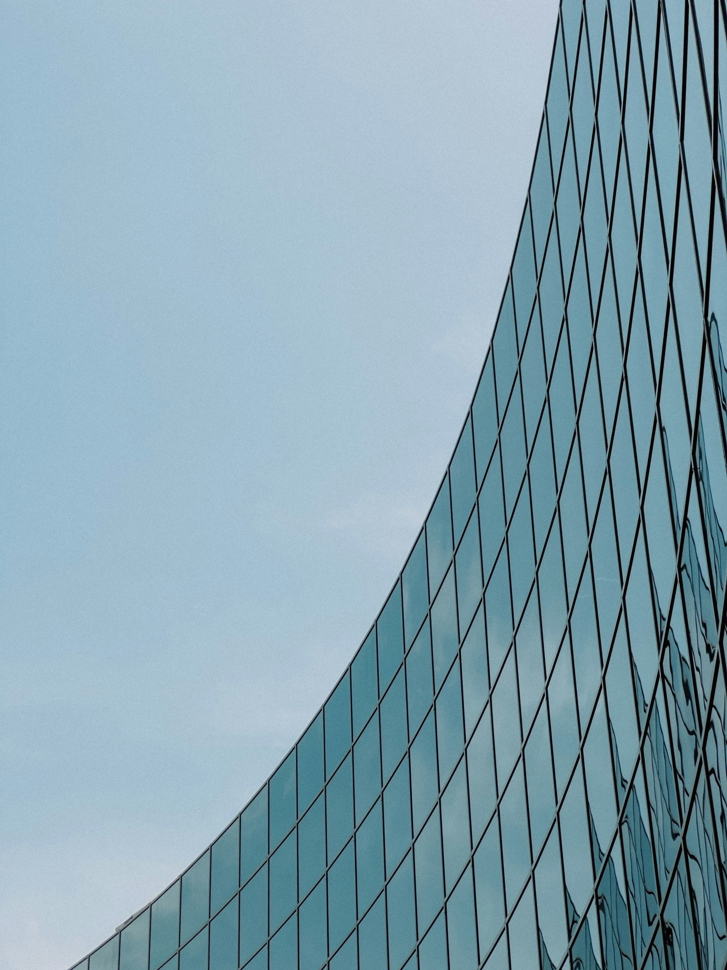 Modern building in Madrid | Curved glass facade of a modern building against sky