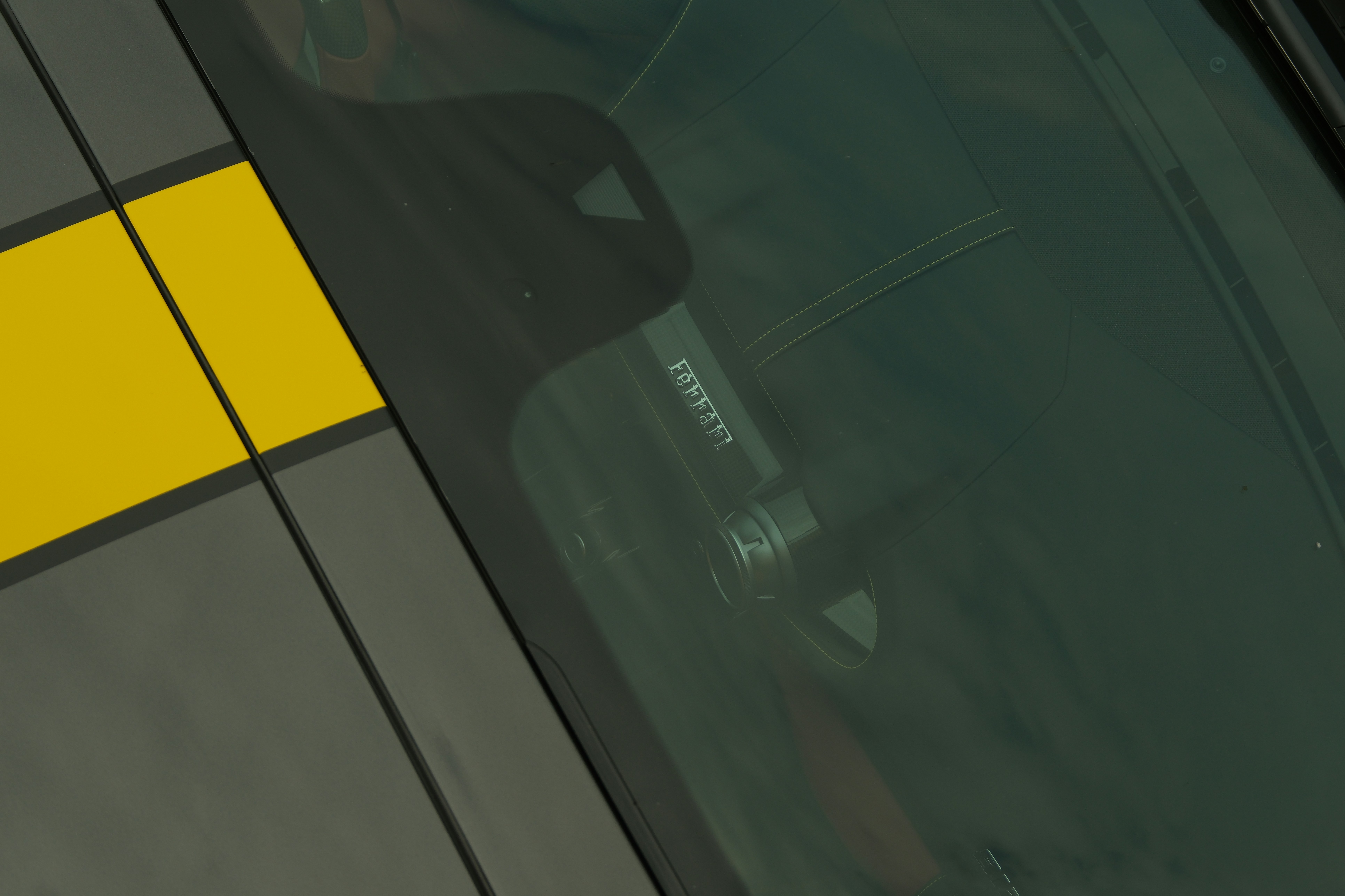 Yellow stripe on a dark surface with reflection