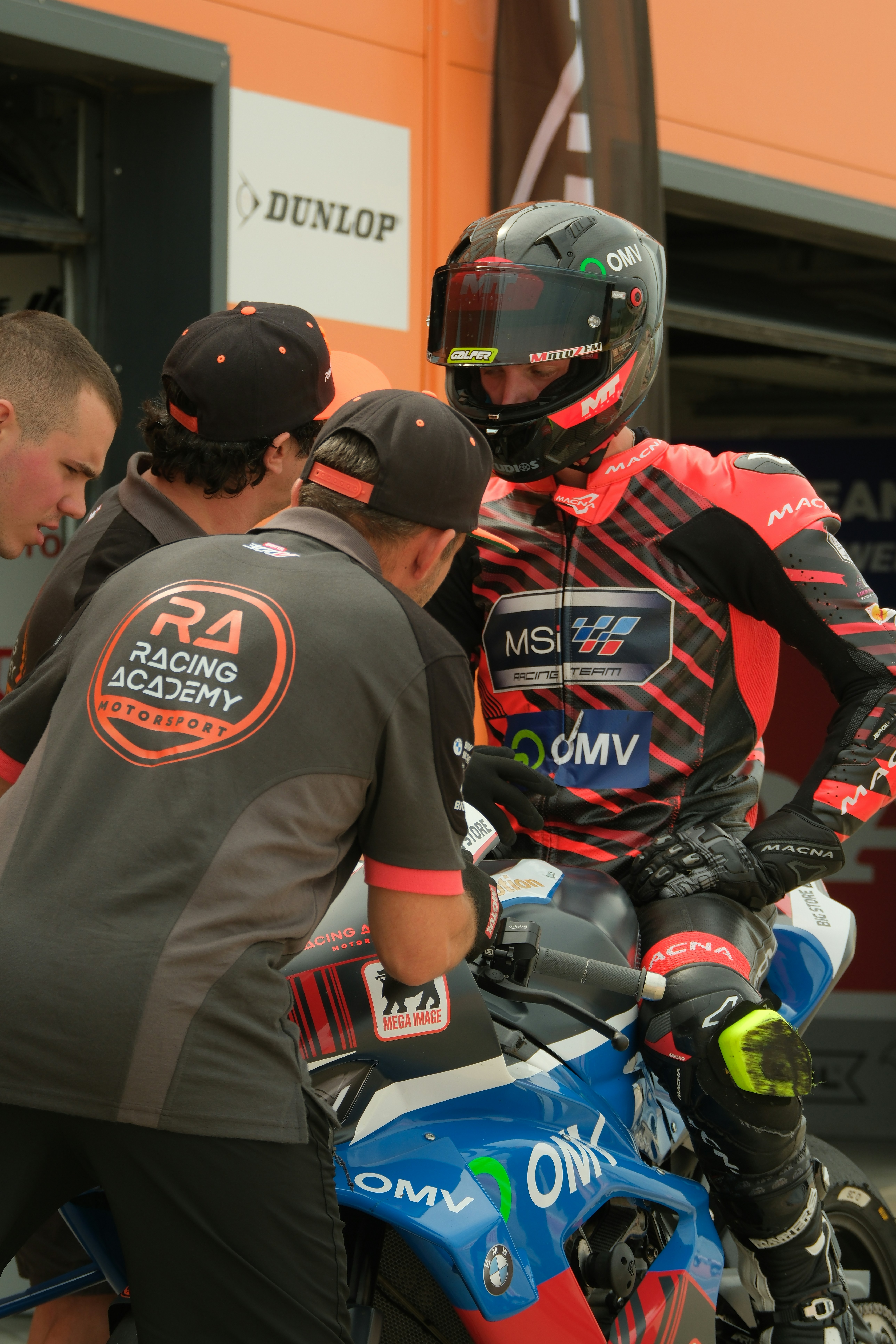 Pit-Huddle Precision: A Racer Gathers with the Crew in the Pit