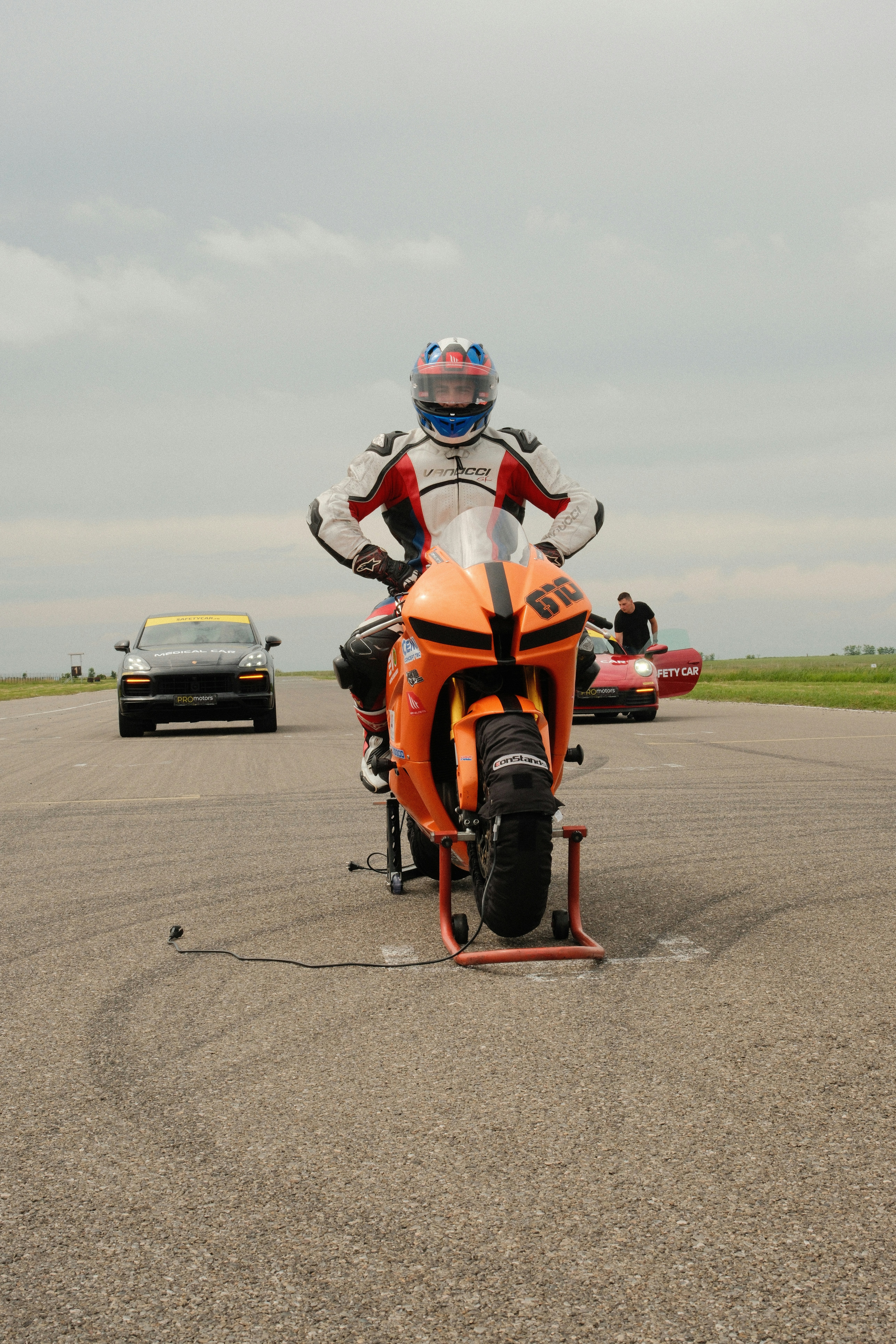 Orange Racer at Center Stage: Runway Balance Under a Wide Sky
