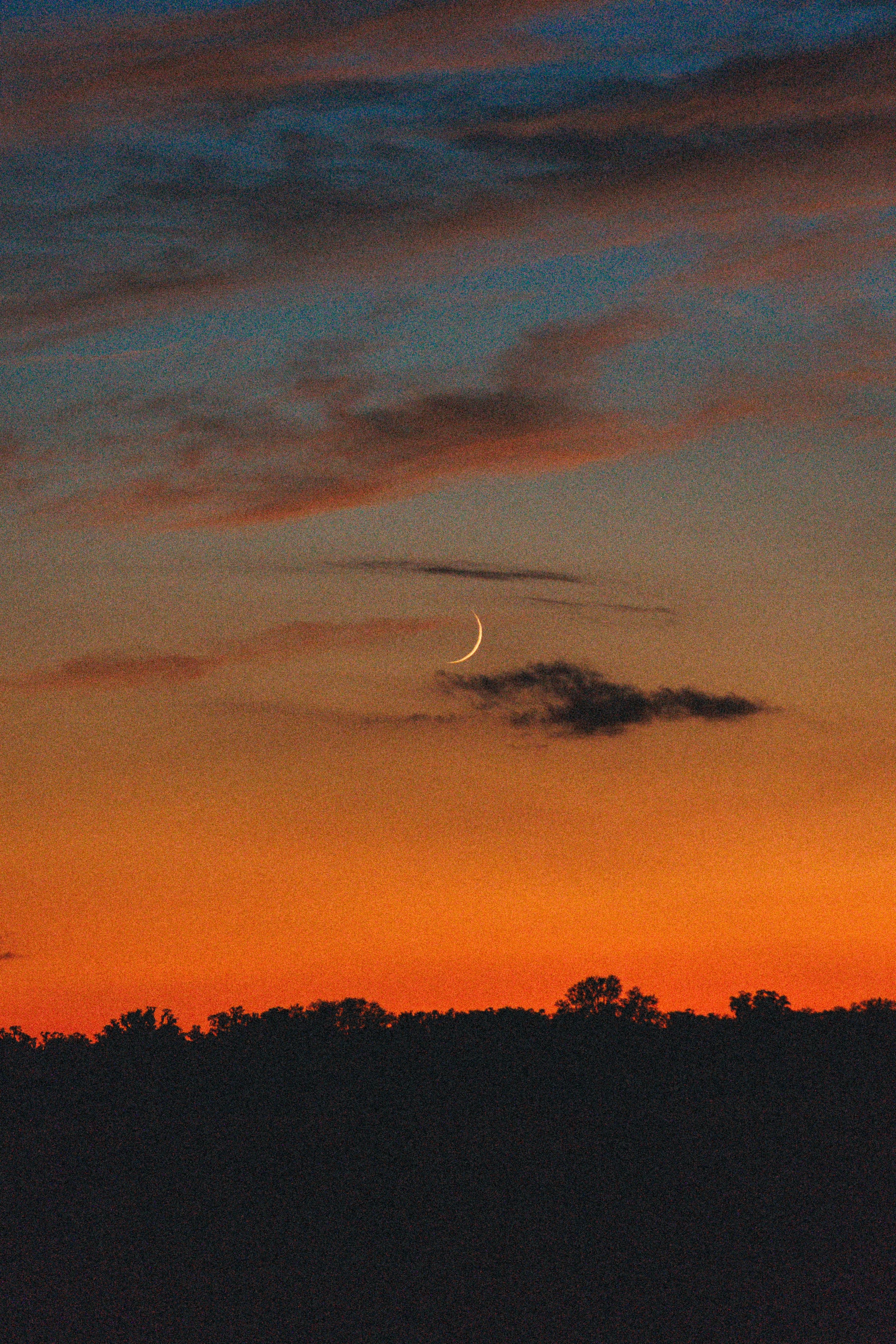 Crescent moon in a vibrant sunset sky