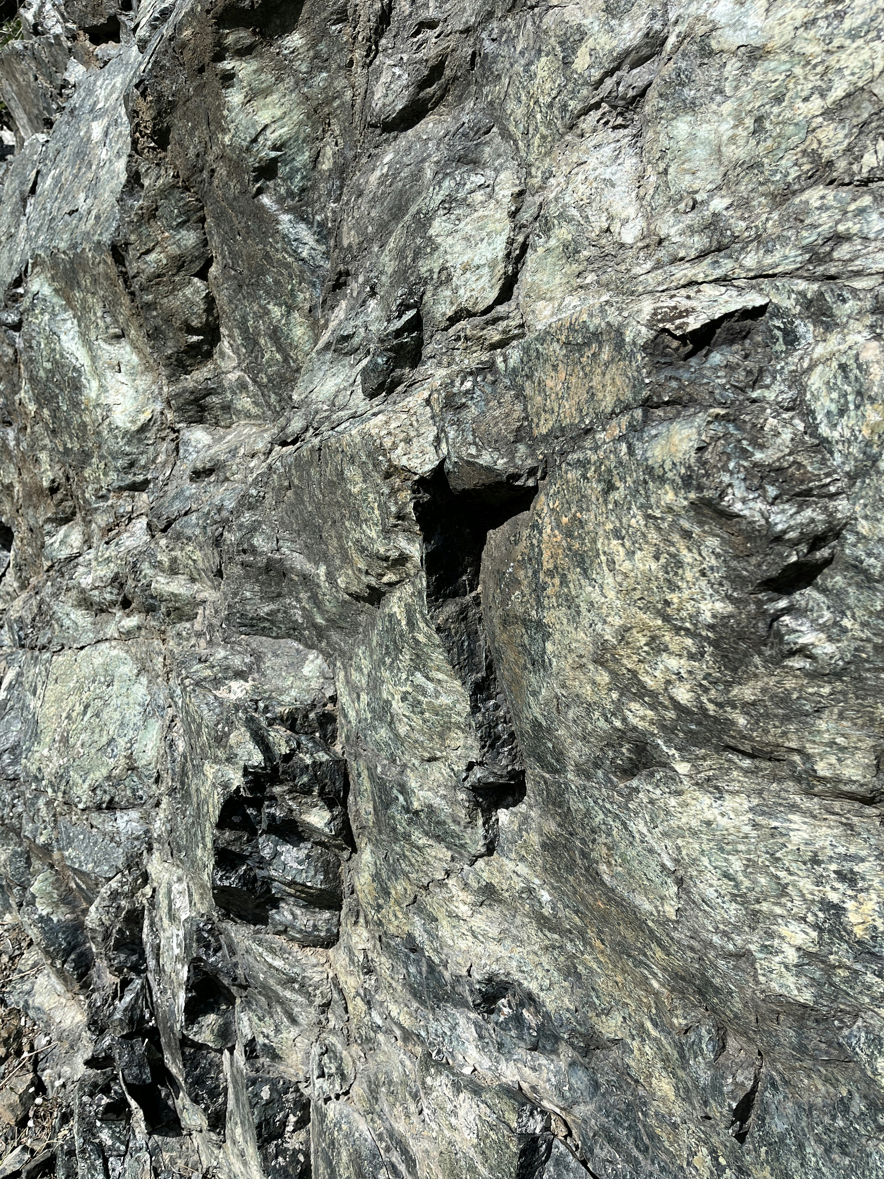 Part of the rocks by the road | Detailed texture of a rough, weathered rock face.