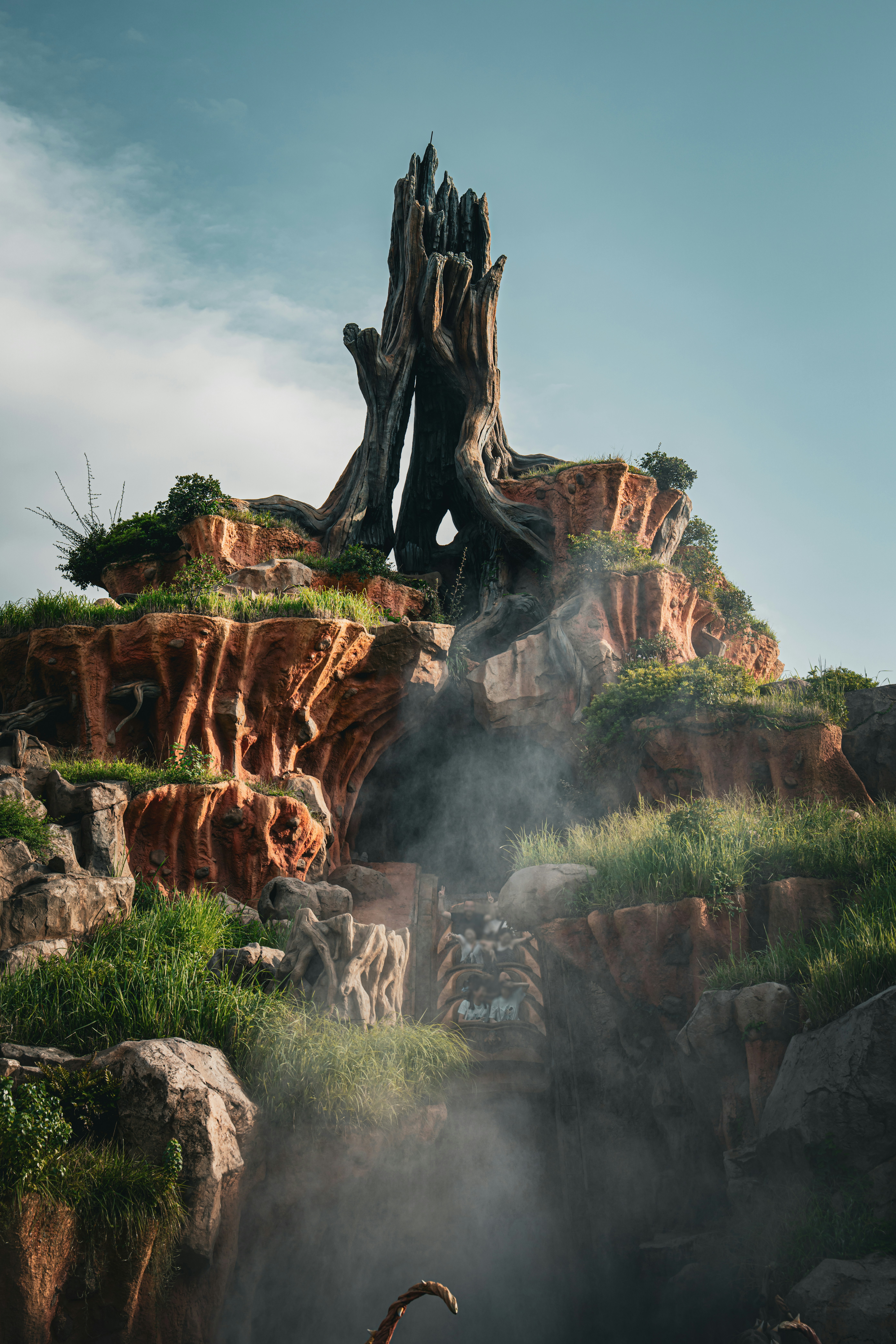 Rocky landscape with a large dead tree and waterfall