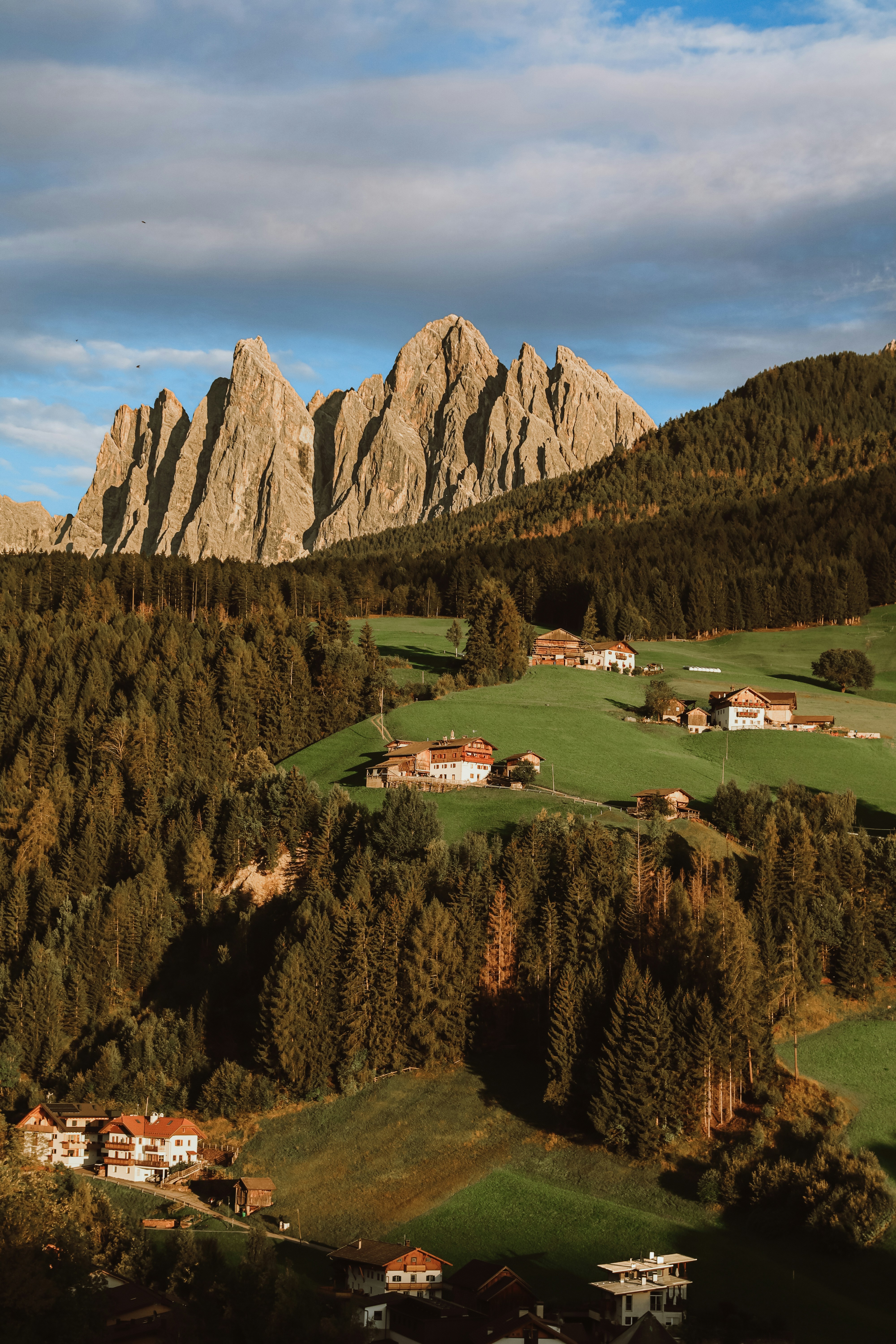Mountain peaks above a village and forest.