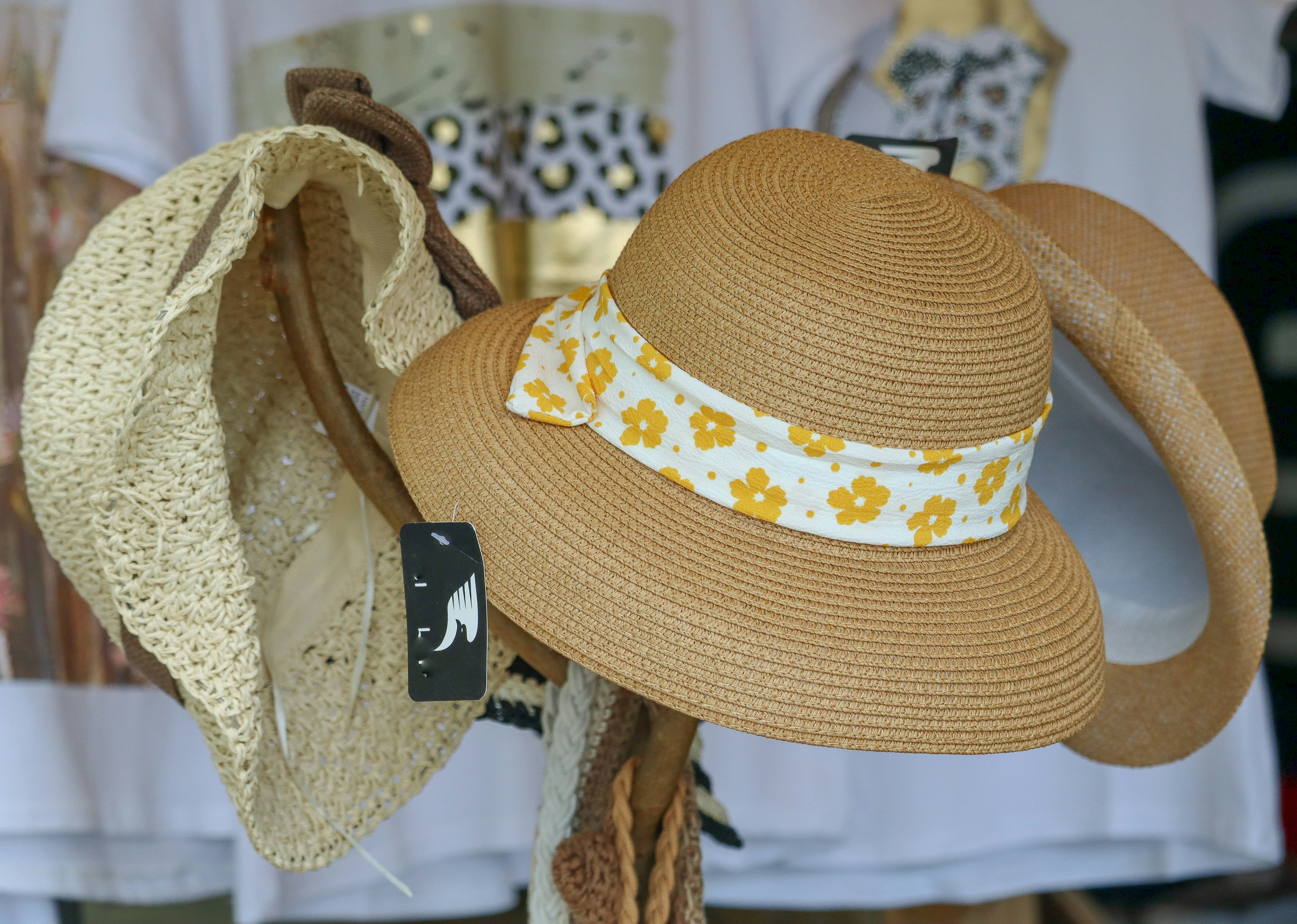 Straw hats with decorative ribbons displayed outdoors