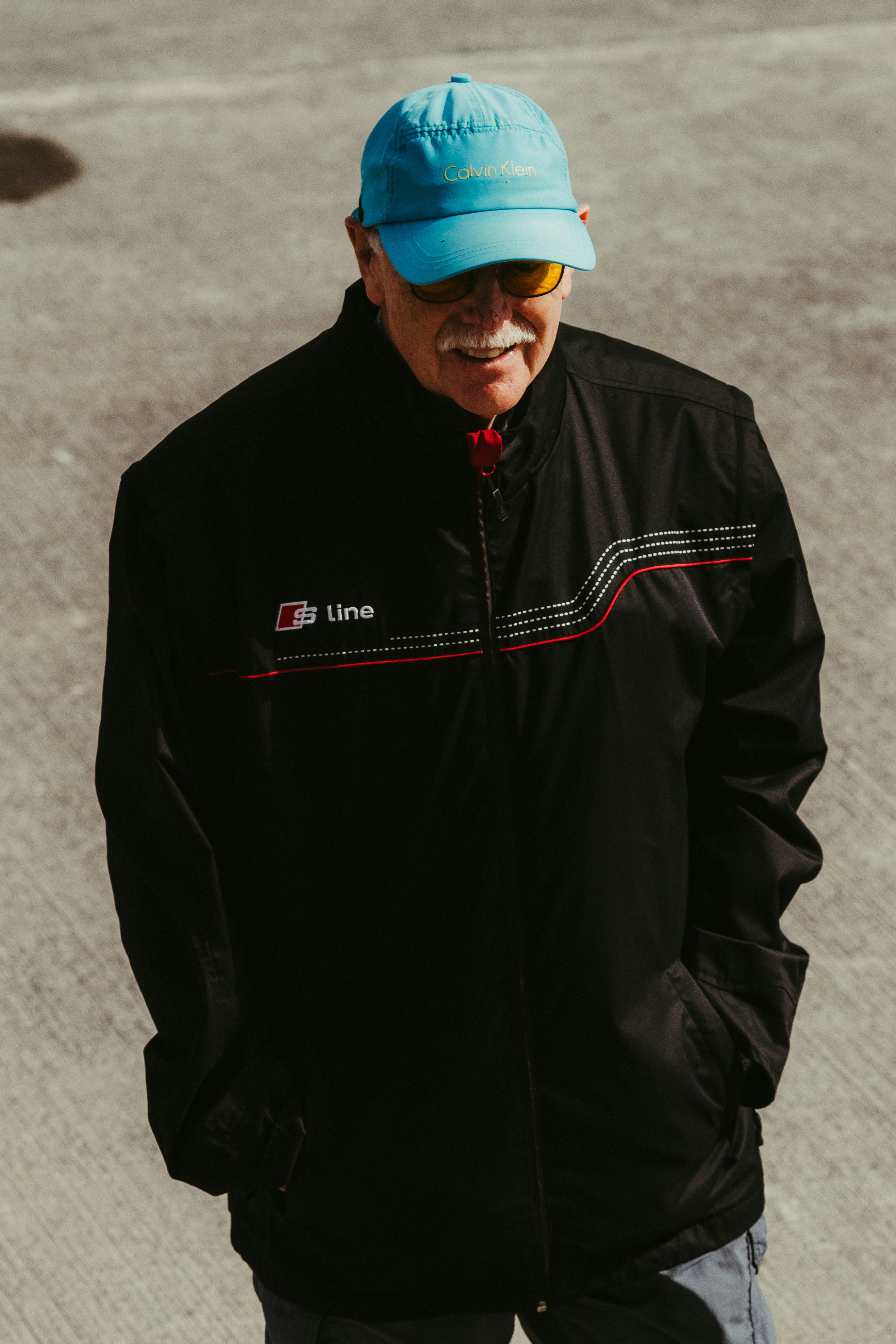 An older man wearing a blue cap and jacket