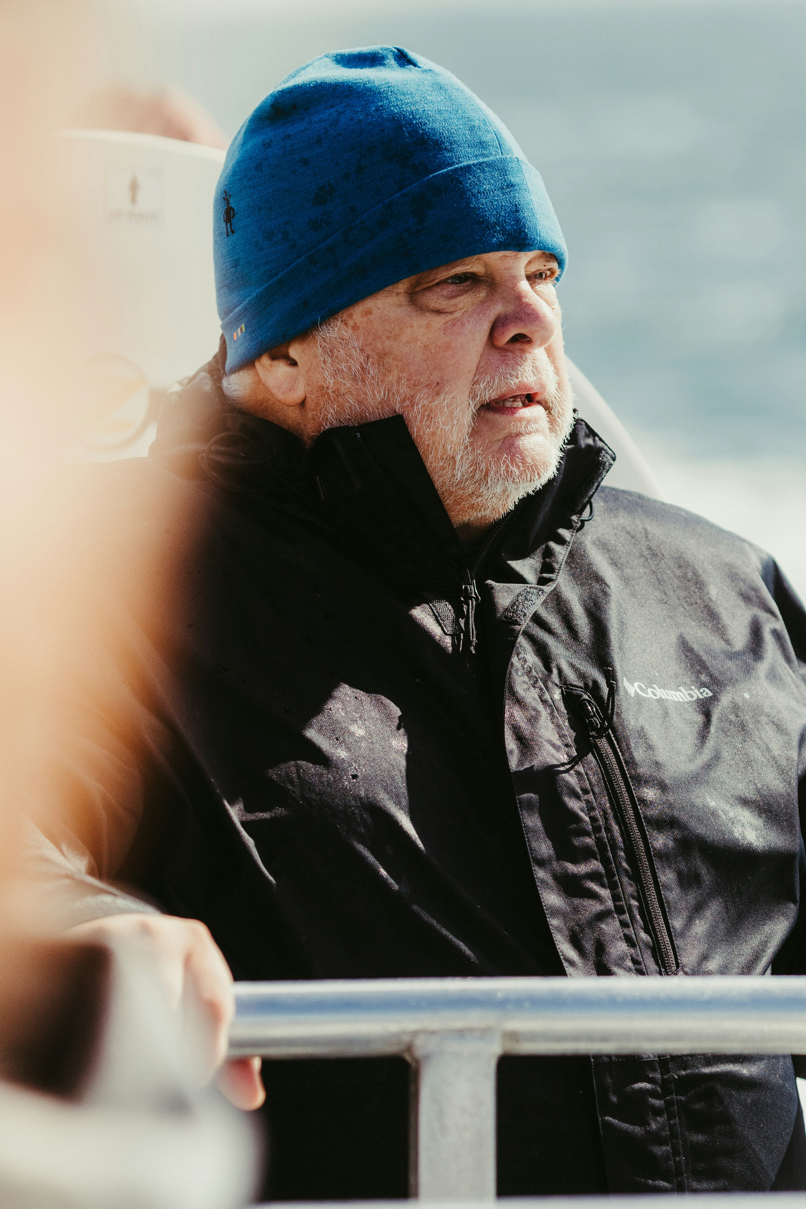 Elderly man wearing a blue beanie and jacket.