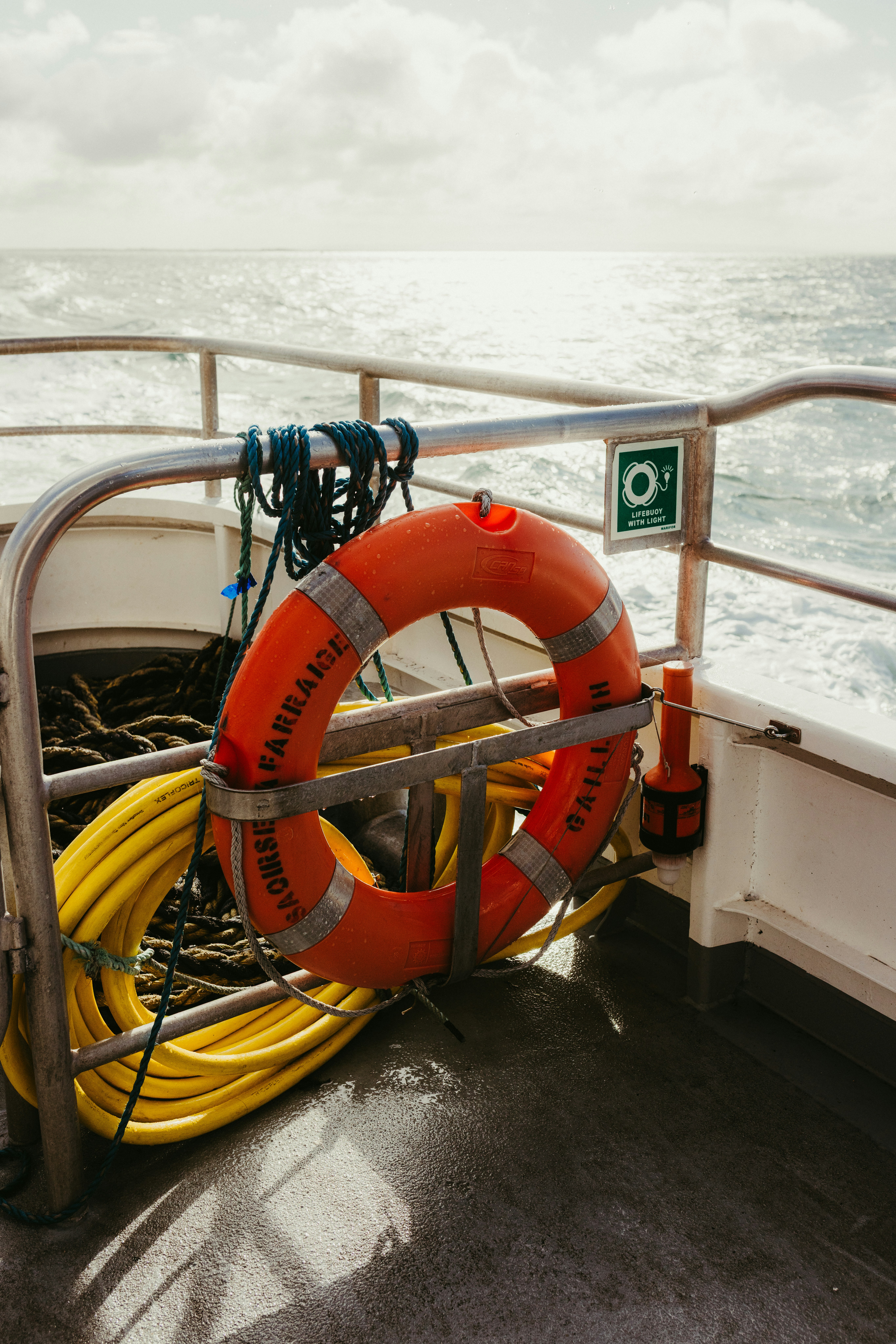 Orange life preserver and yellow rope on boat deck photo – Free Rope ...