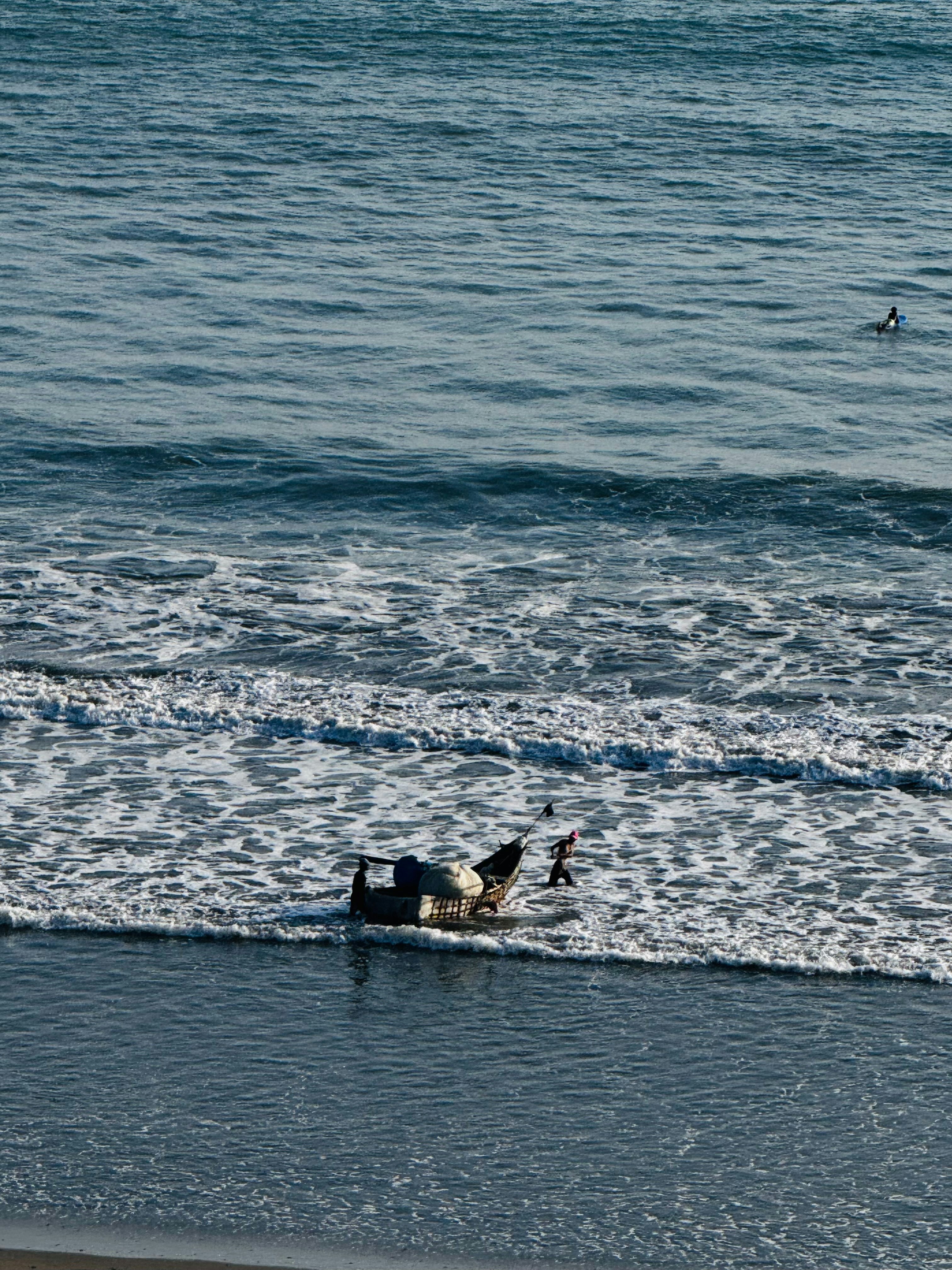 Surfers paddling on surfboards in the ocean waves.