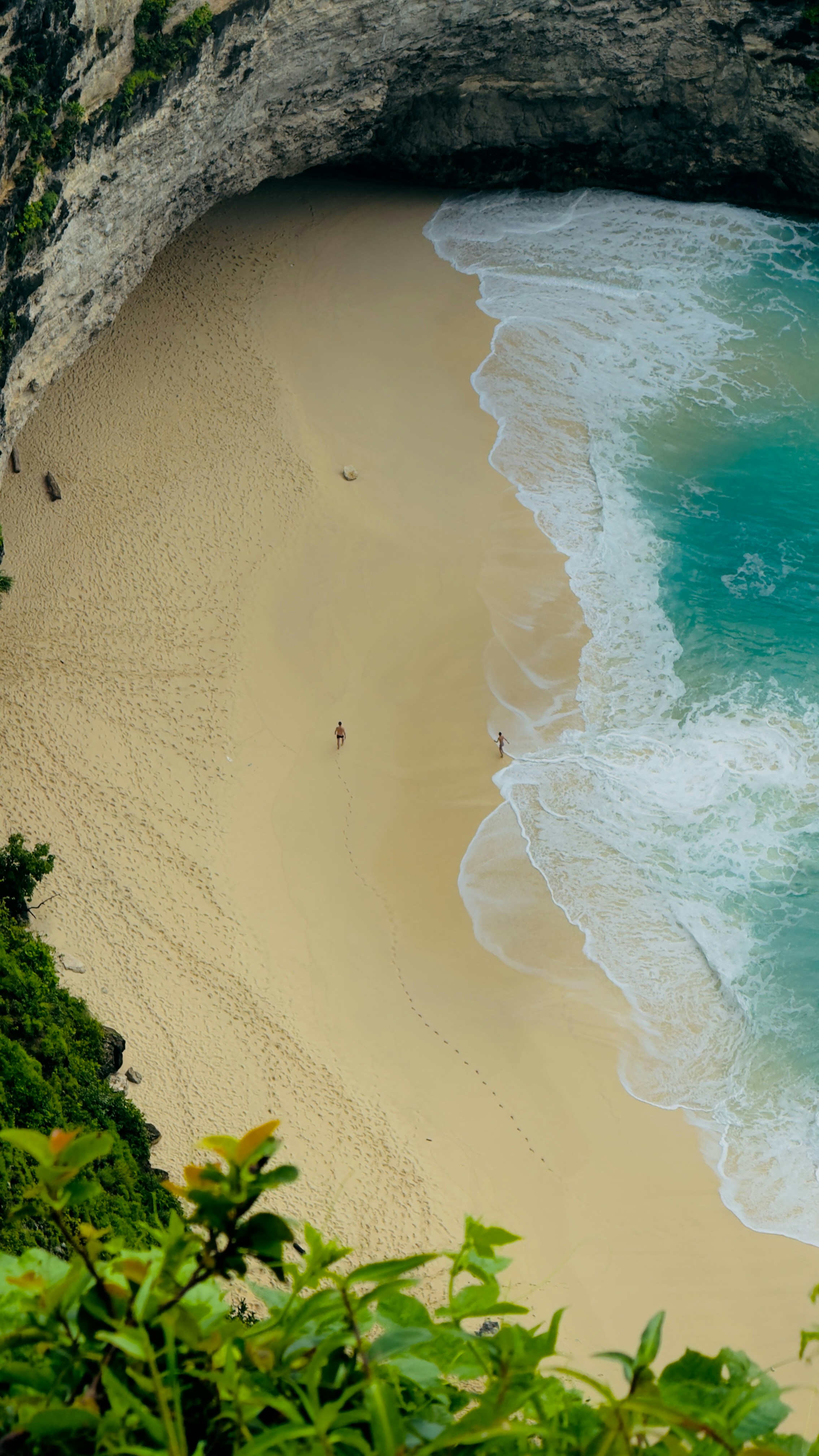 Sandy beach with turquoise waves crashing ashore.