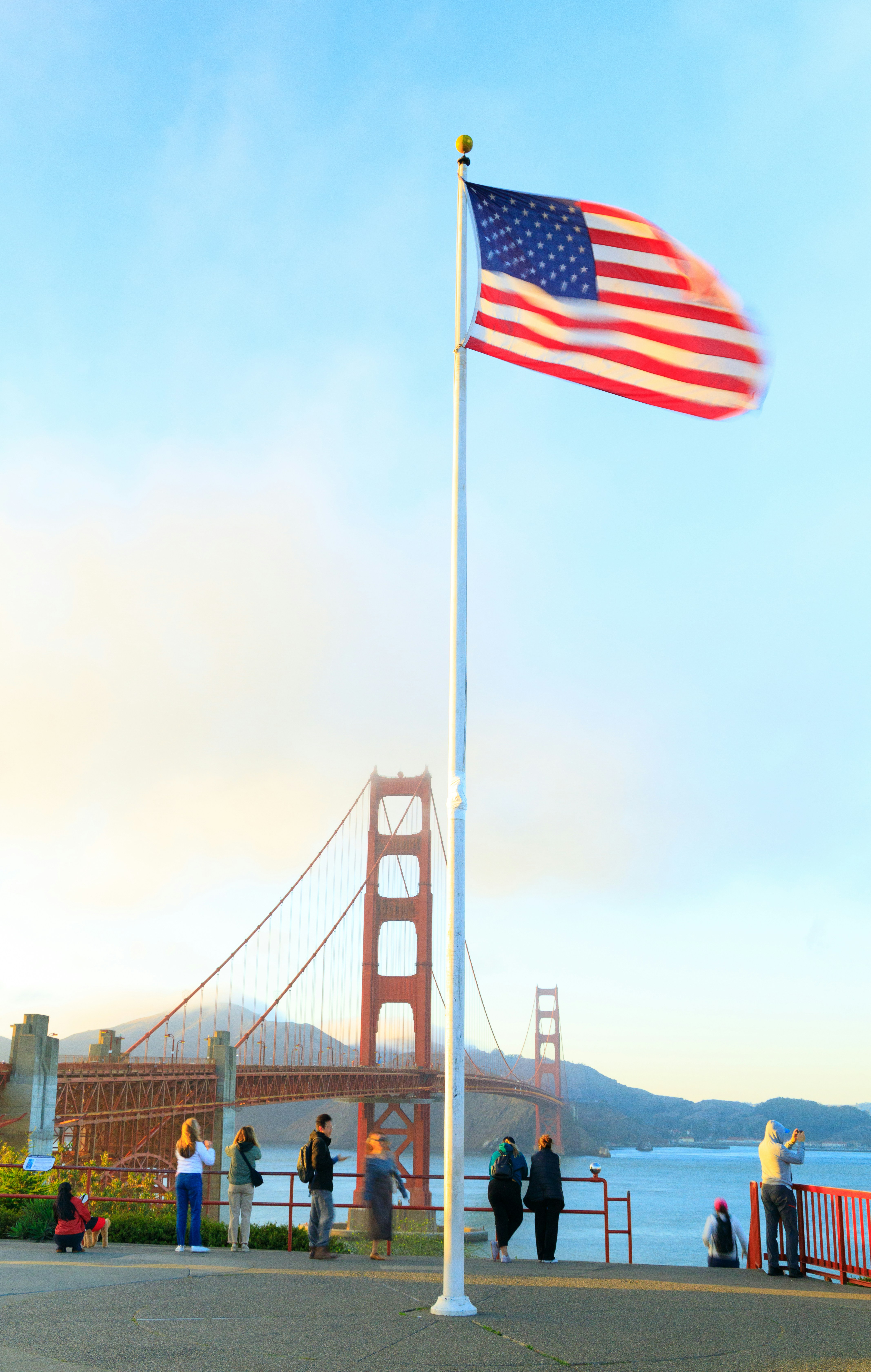 American flag flies near golden gate bridge with onlookers photo – Free ...