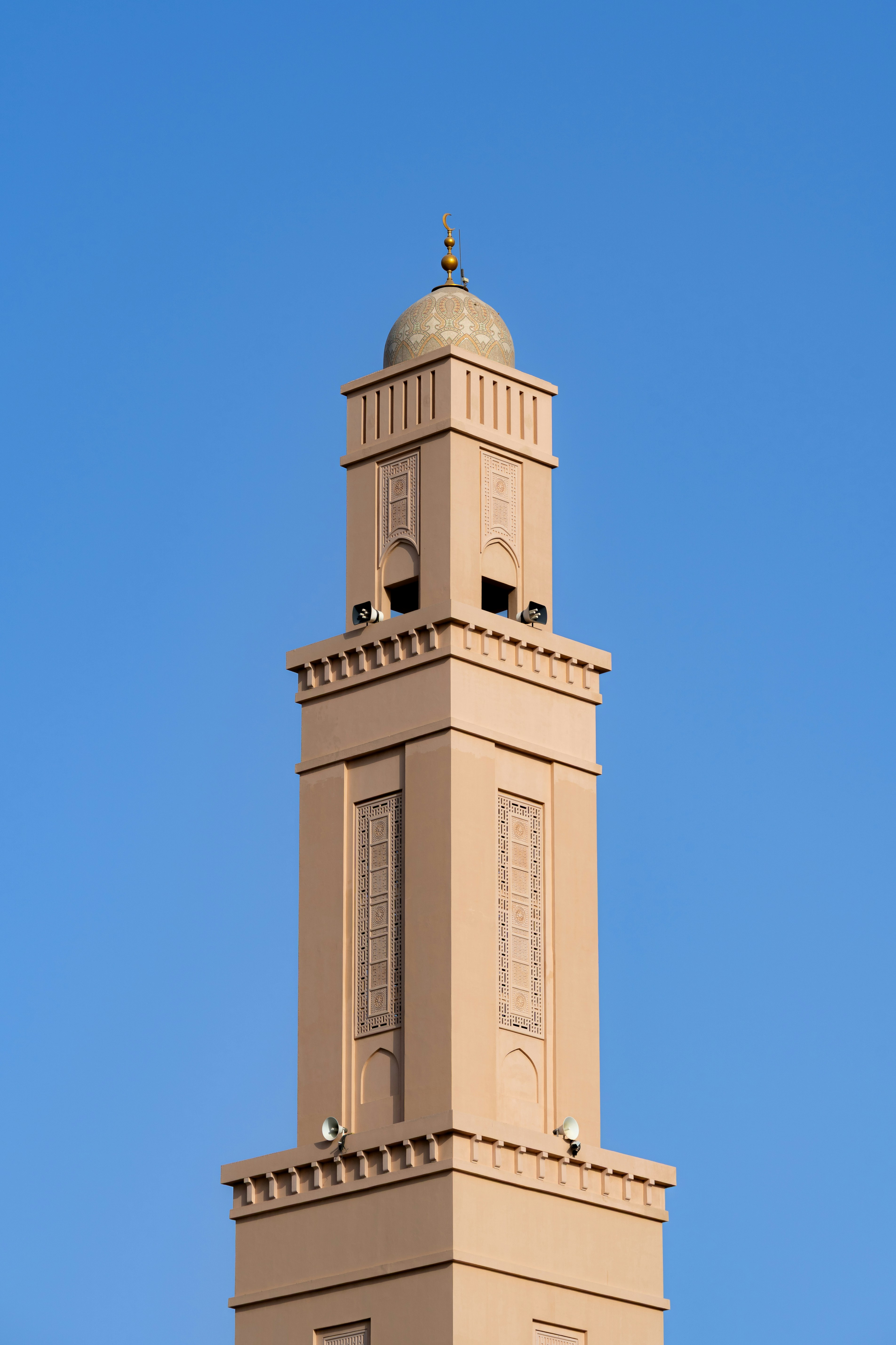 Tall mosque minaret against a clear blue sky