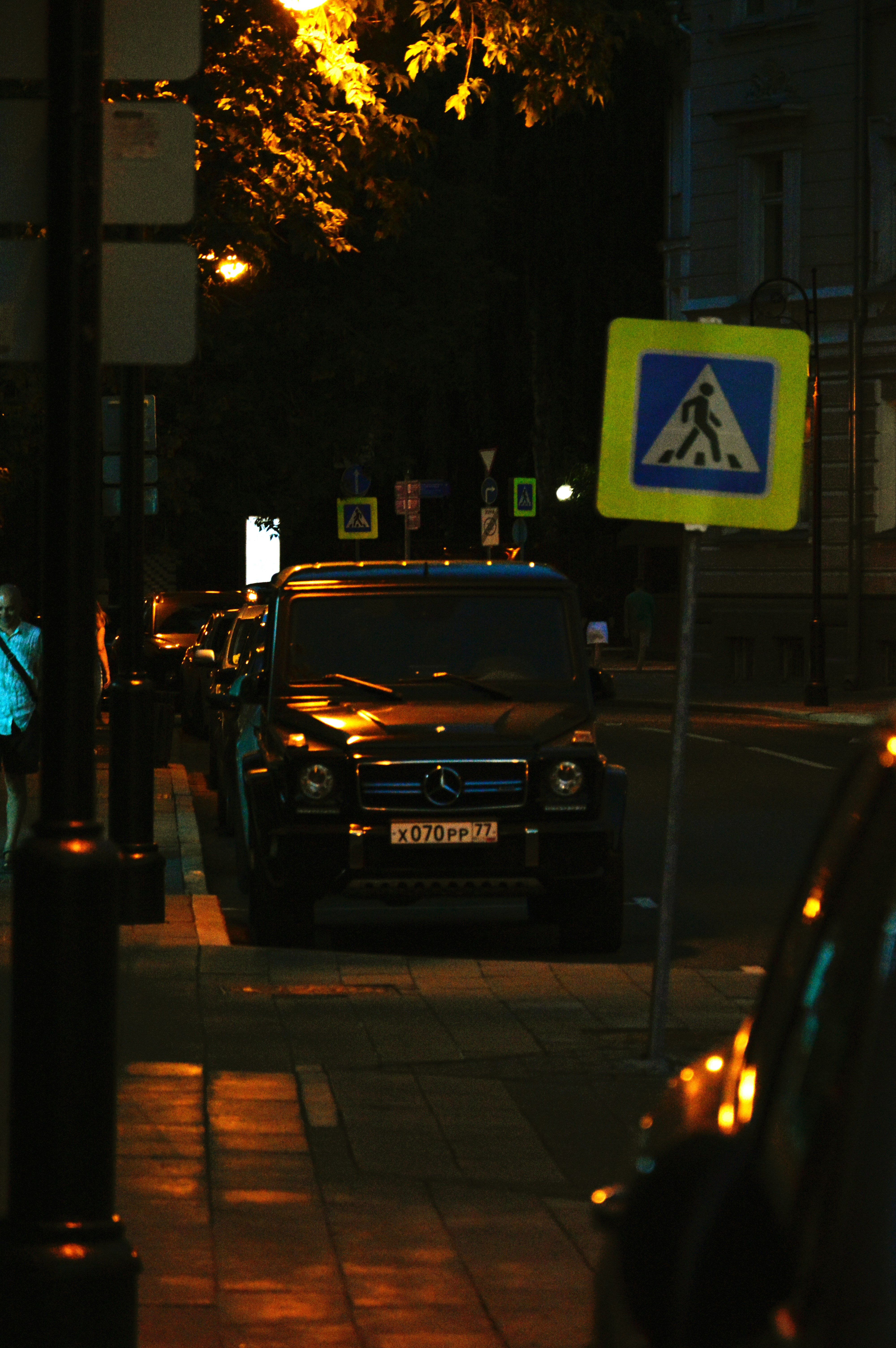 Black suv parked on a city street at night.