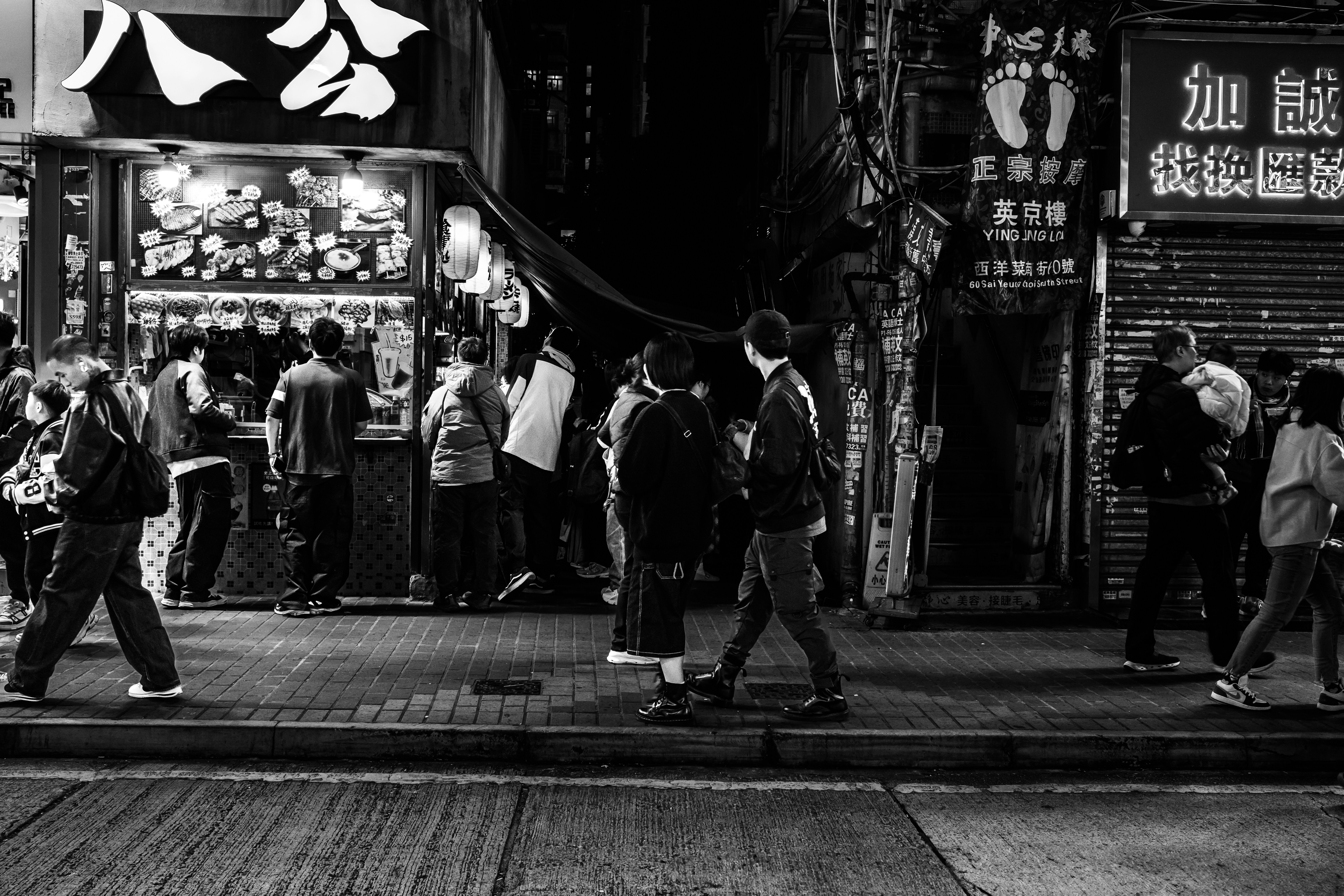 You look, and see nothing. But in that nothing, everything pulses — a world built from the weight of silence and the noise of absence. | People walking on a street at night